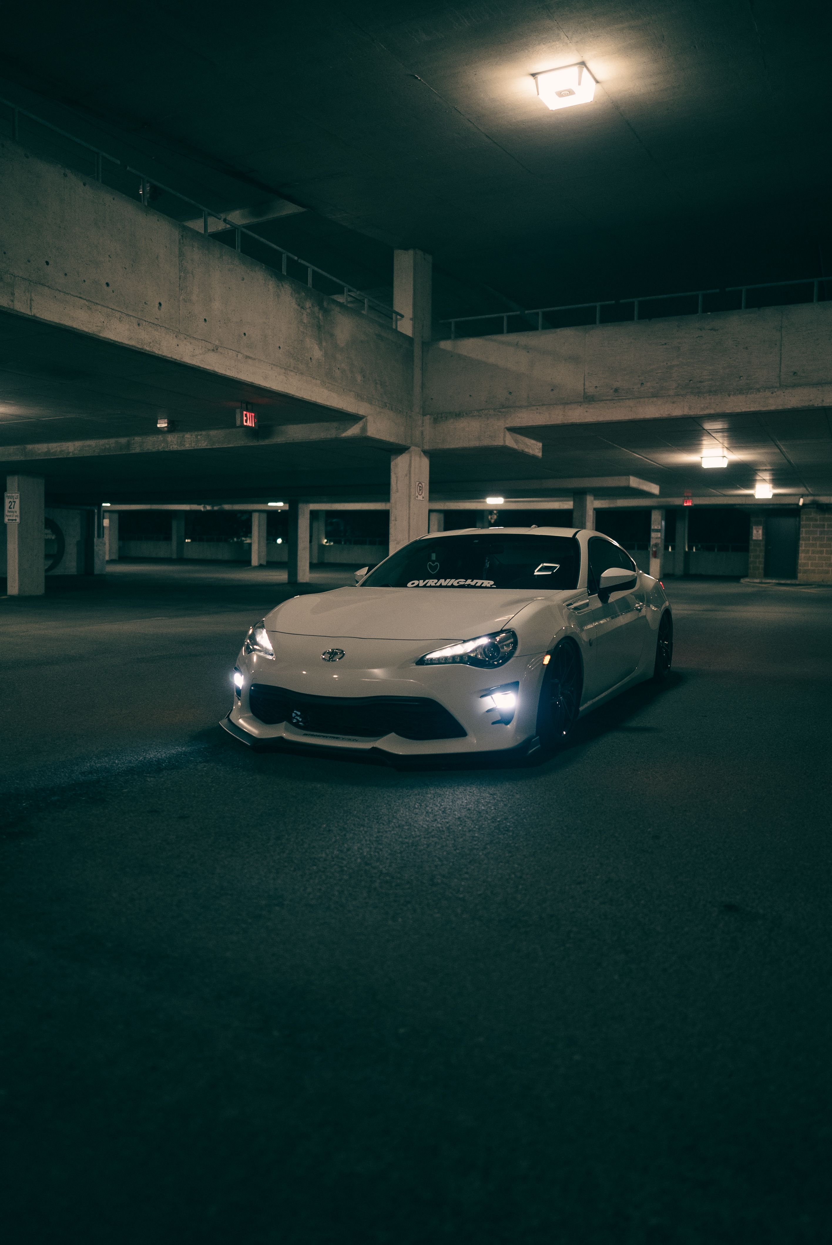 White sports car in dimly lit parking garage · Free Stock Photo
