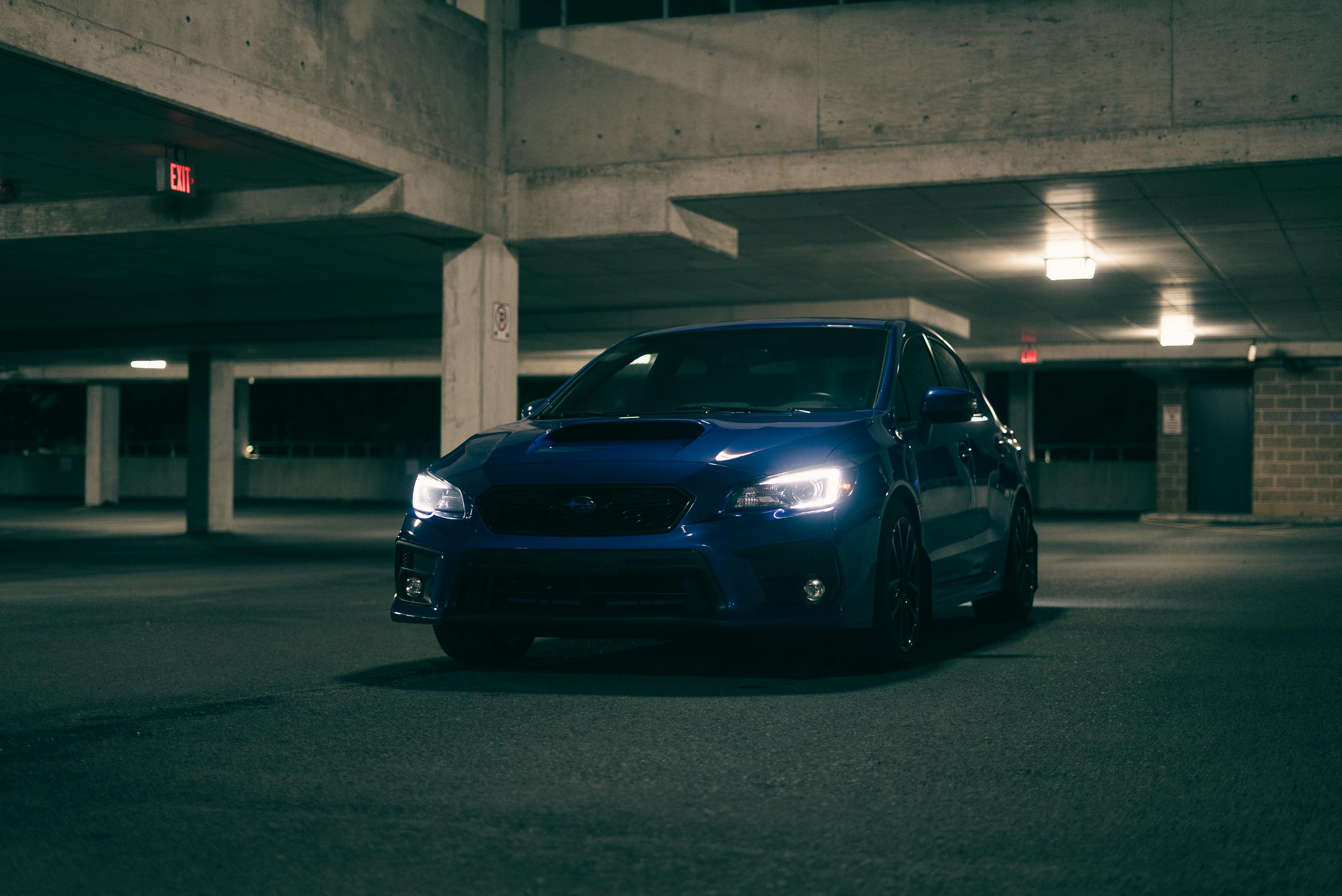 Blue Car in Dimly Lit Urban Parking Garage · Free Stock Photo
