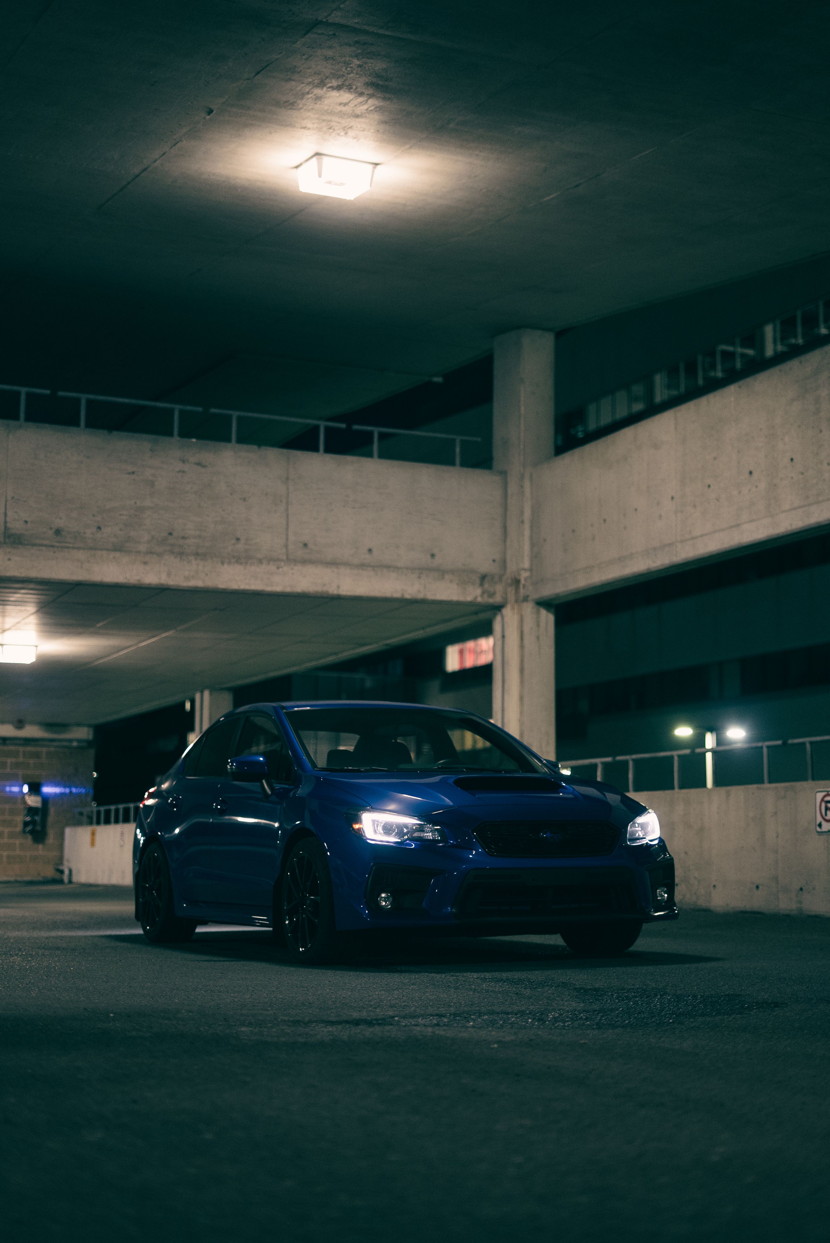 Sleek Blue Car in Dimly Lit Parking Garage · Free Stock Photo