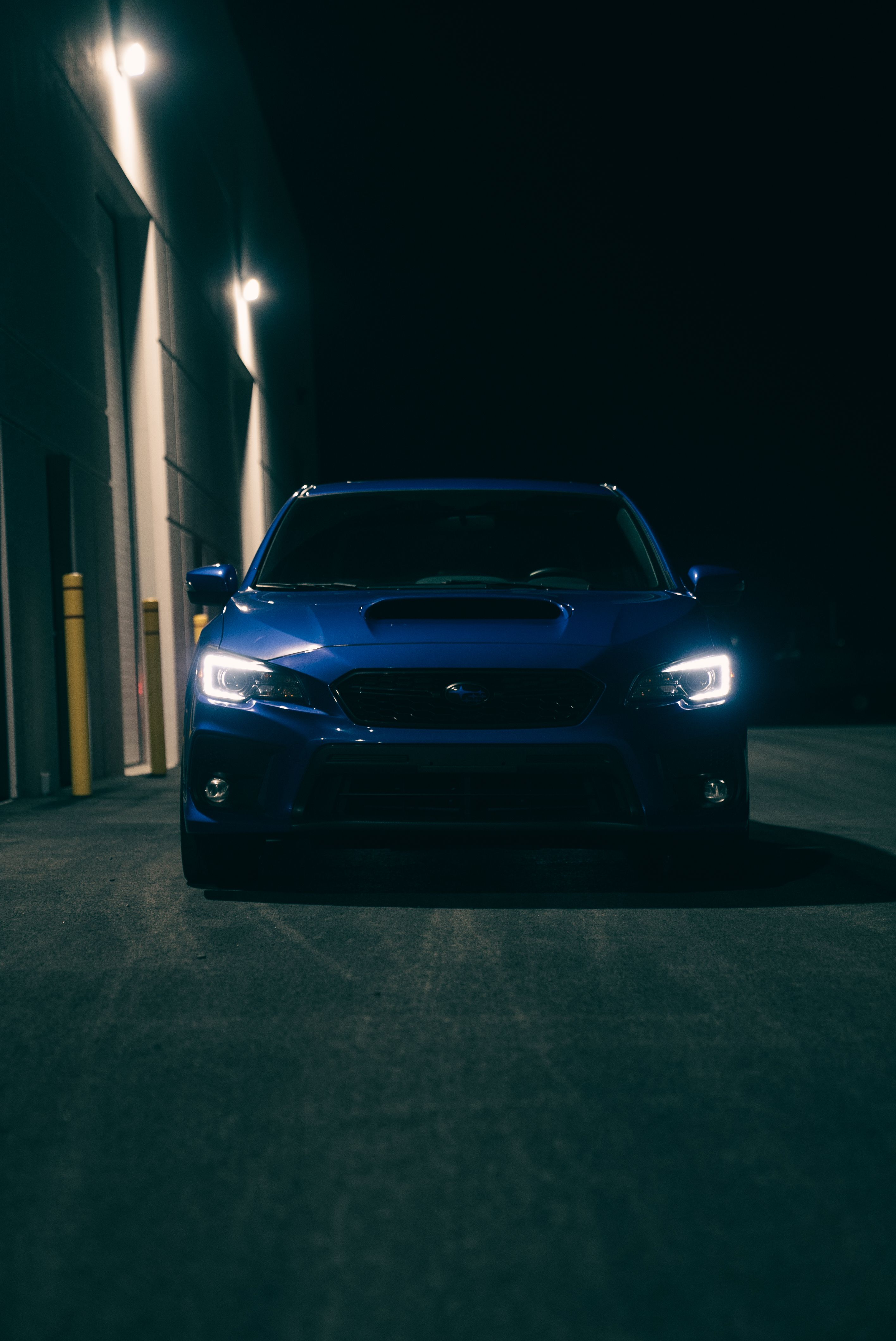 Nighttime Front View of Blue Car with Headlights On · Free Stock Photo