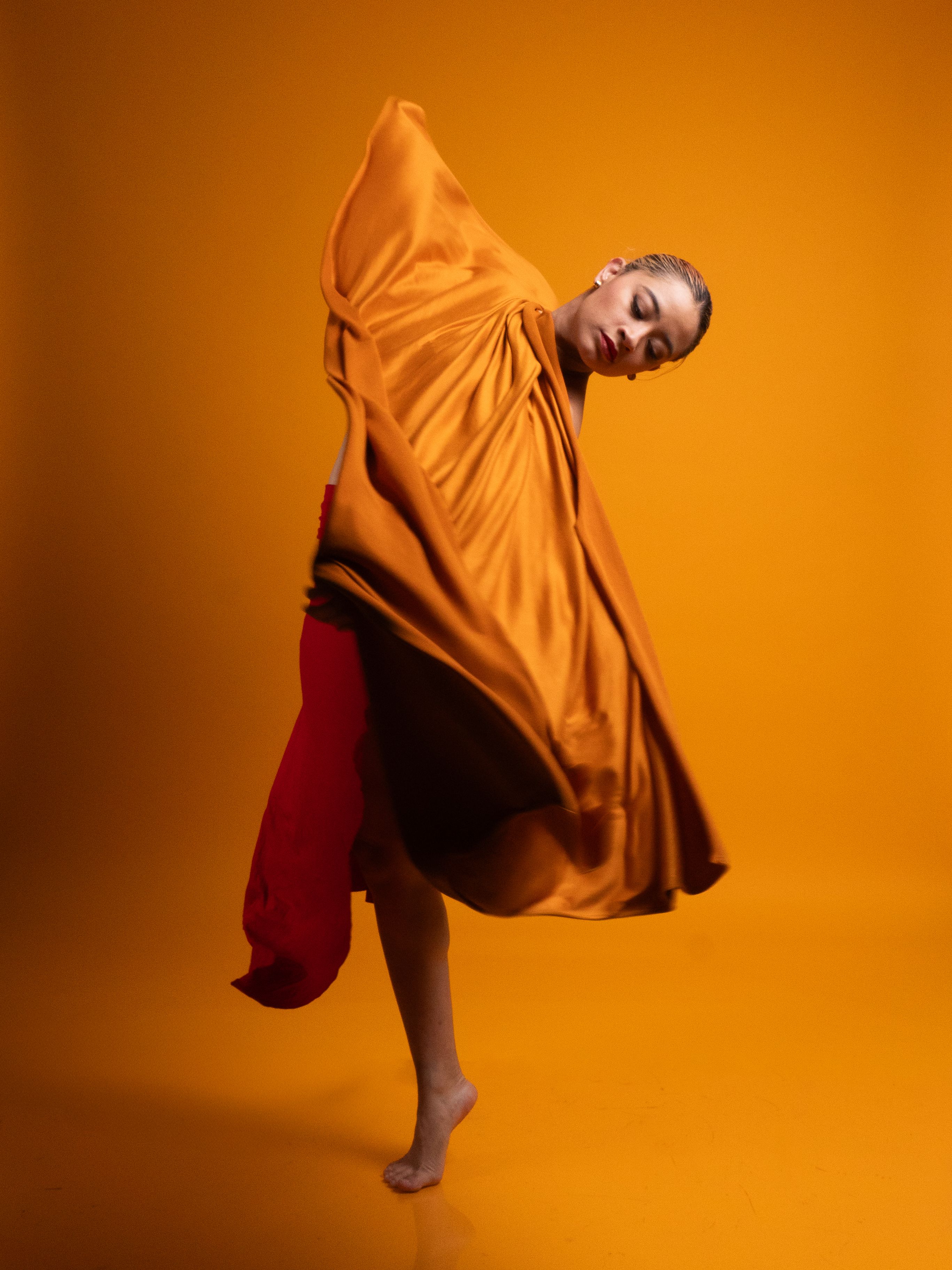 Dynamic Female Dancer in Orange Studio Setting · Free Stock Photo