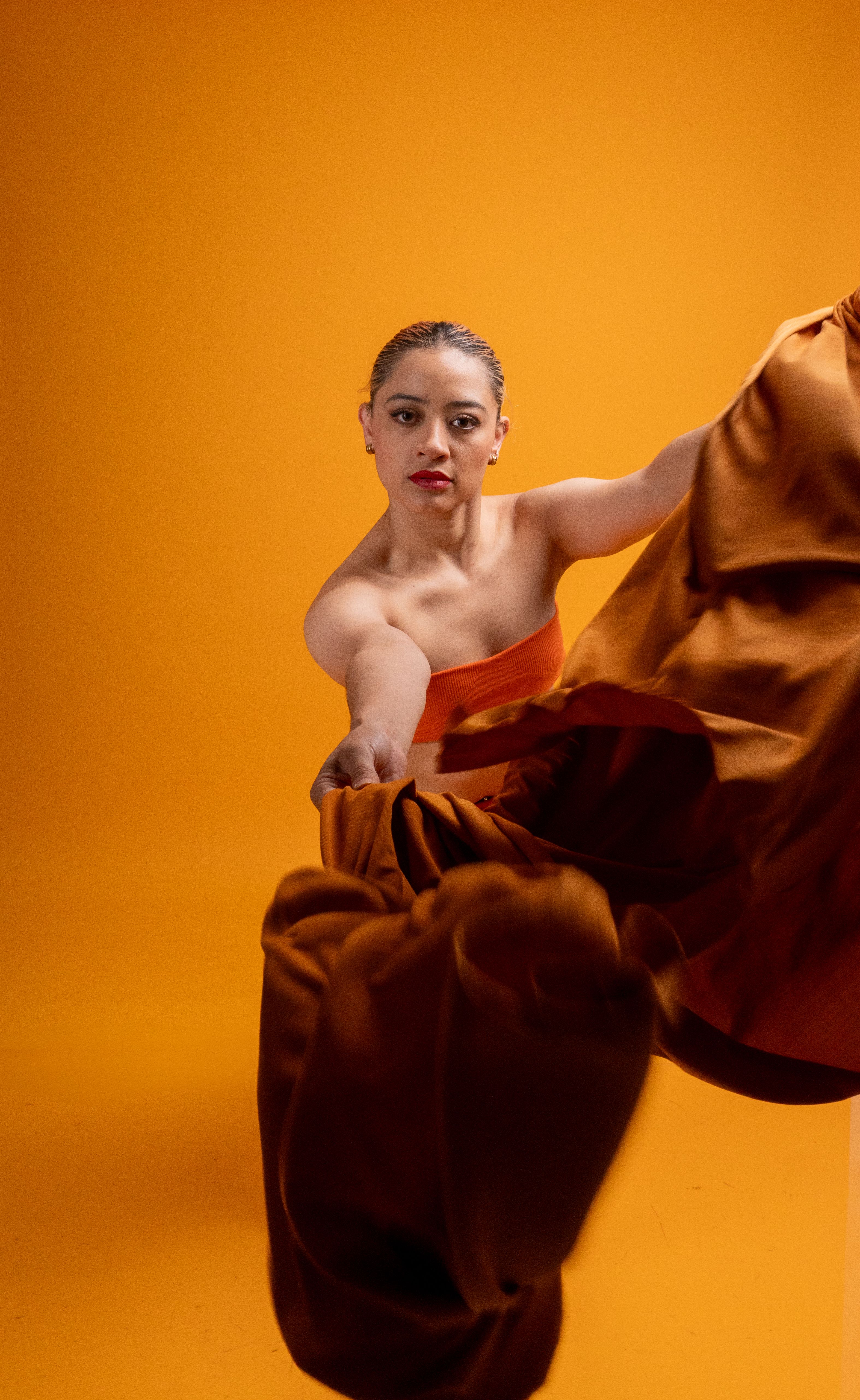 Elegant Female Dancer Posing in Flowing Orange Dress · Free Stock Photo