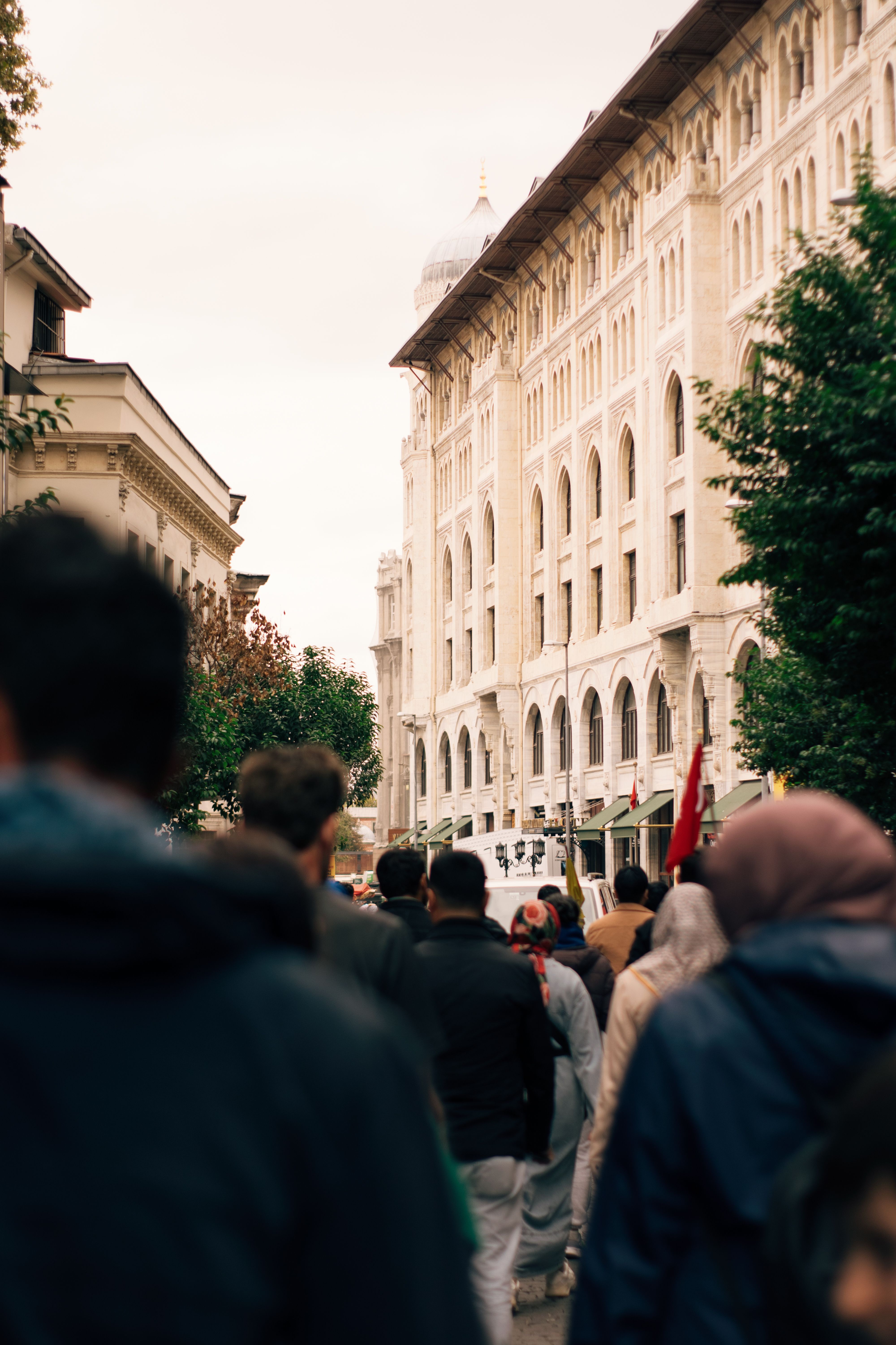 Crowd walking through historic city architecture · Free Stock Photo
