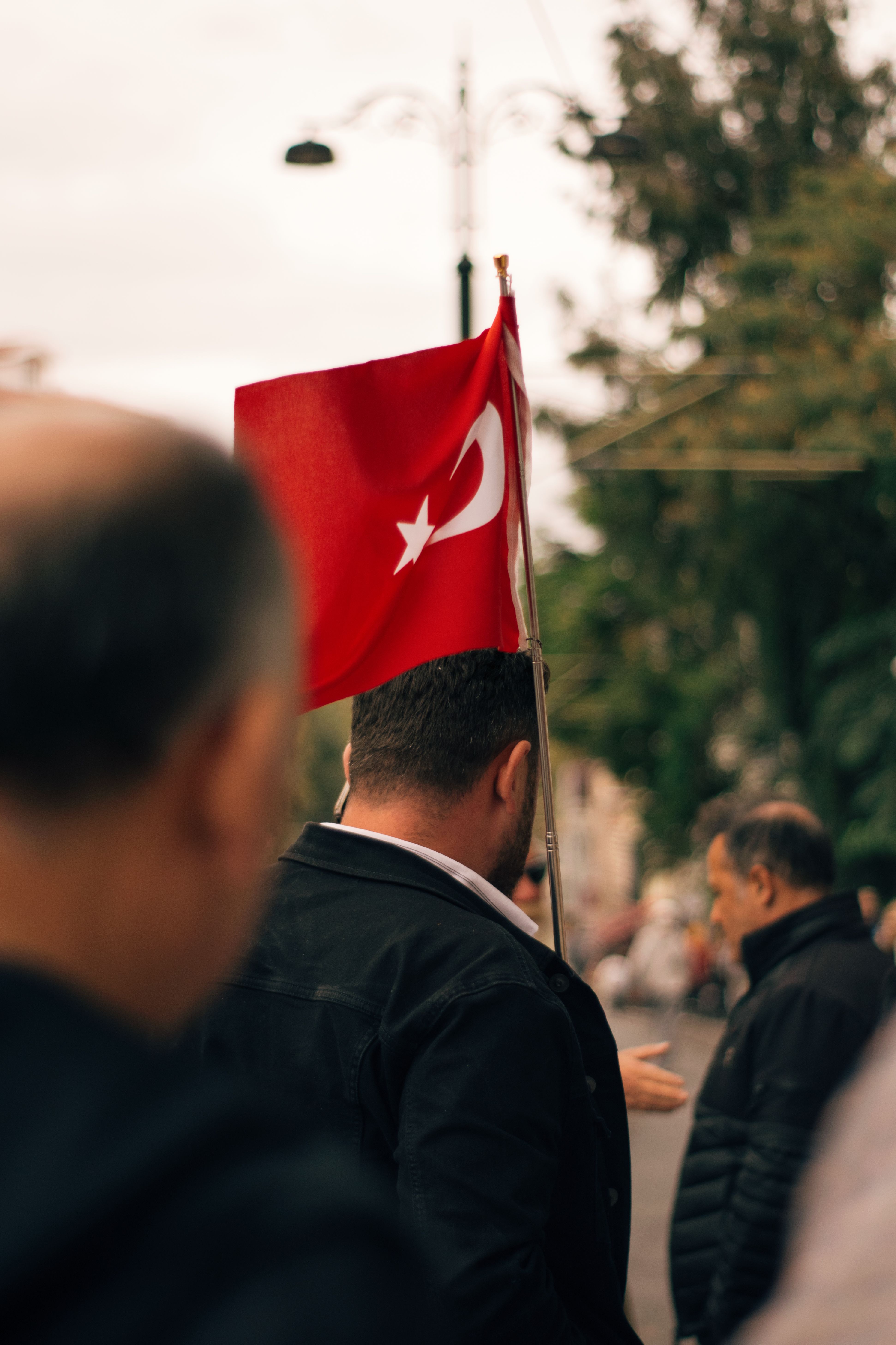 Man Holding Turkish Flag in Urban Street Setting · Free Stock Photo