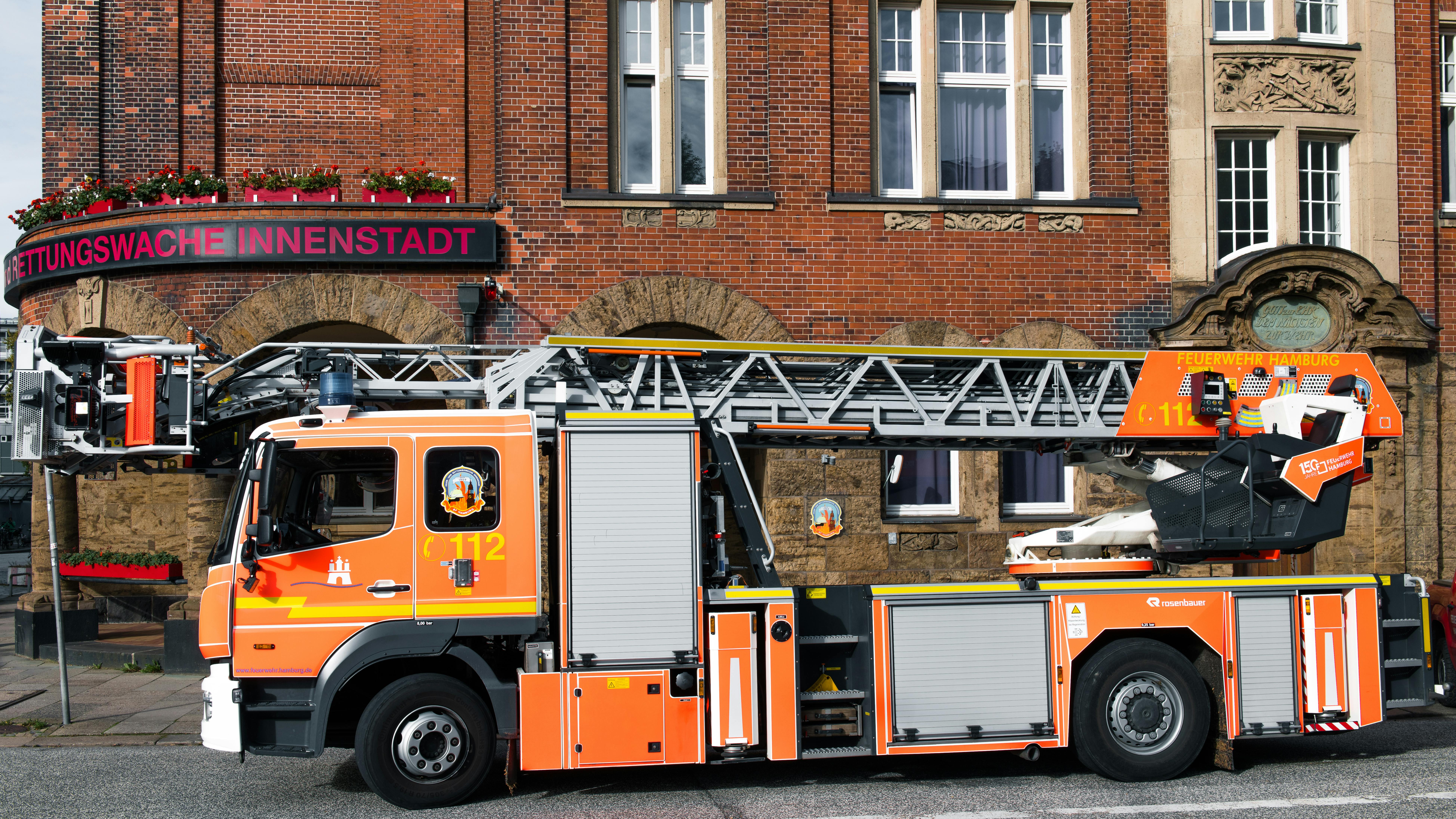 Fire engine truck driving along narrow busy street · Free Stock Photo