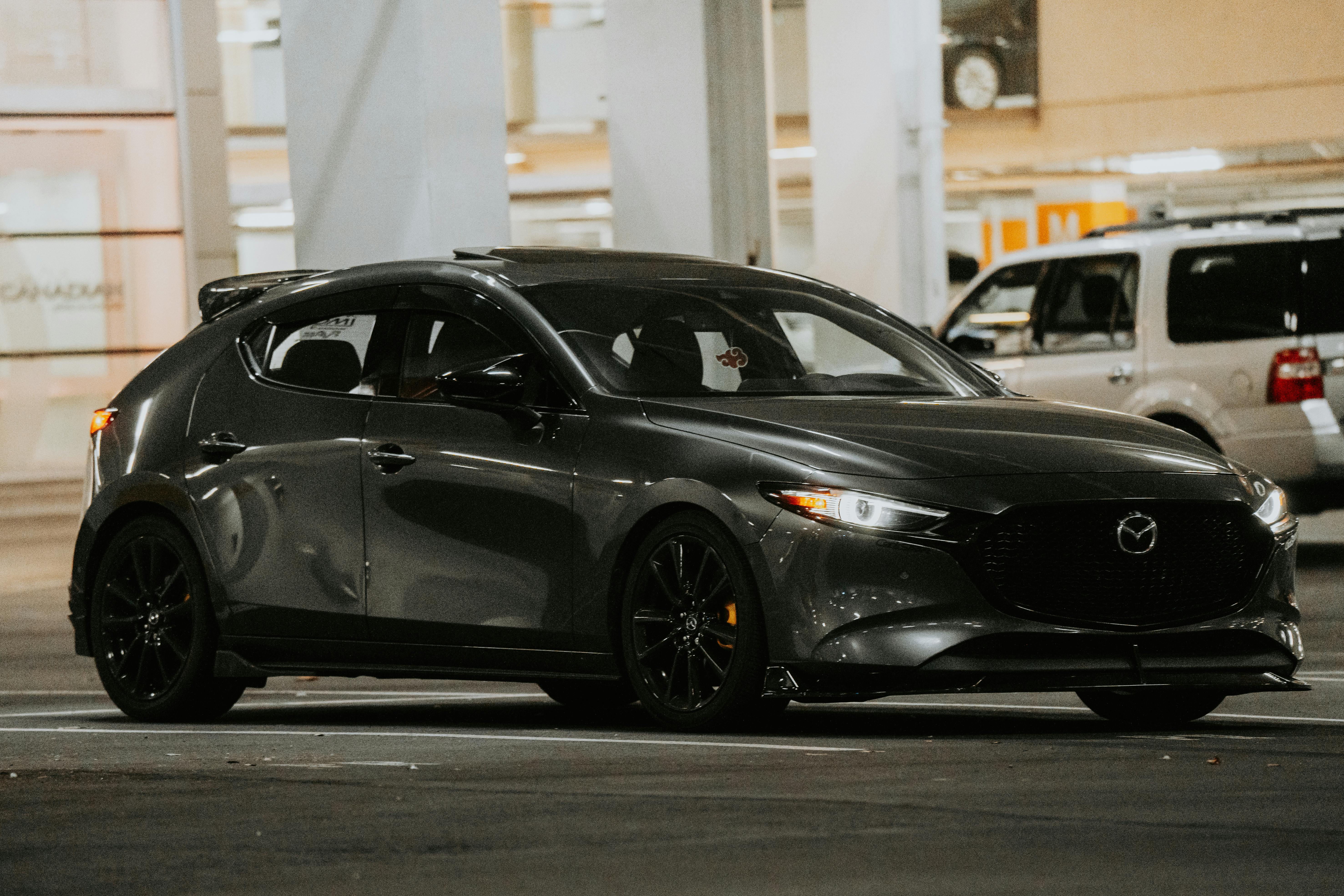 Sleek Black Car in Urban Parking Garage · Free Stock Photo