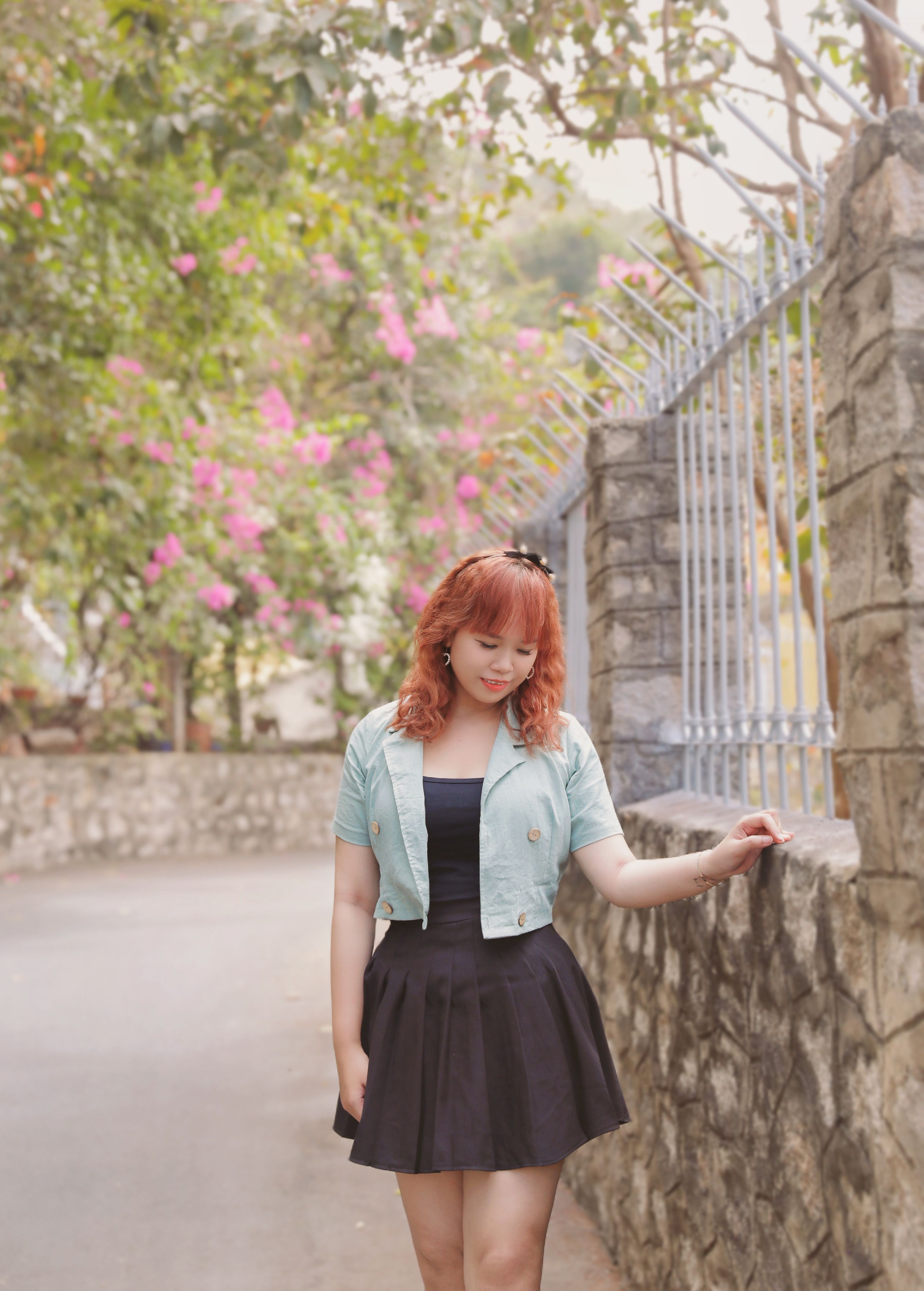 Woman Walking Along Floral Pathway in Spring · Free Stock Photo
