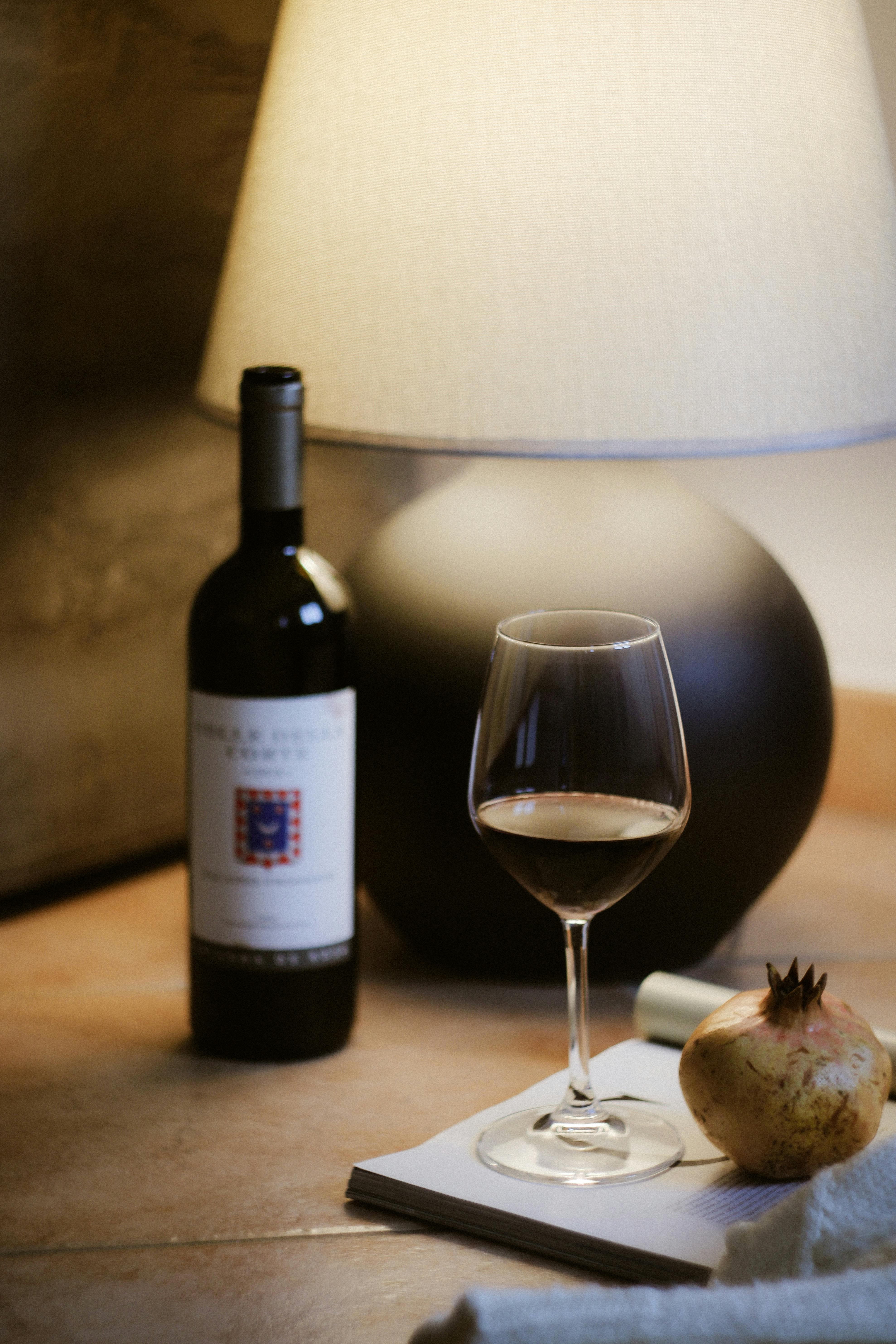 Elegant Wine Setup with Glass and Pomegranate · Free Stock Photo