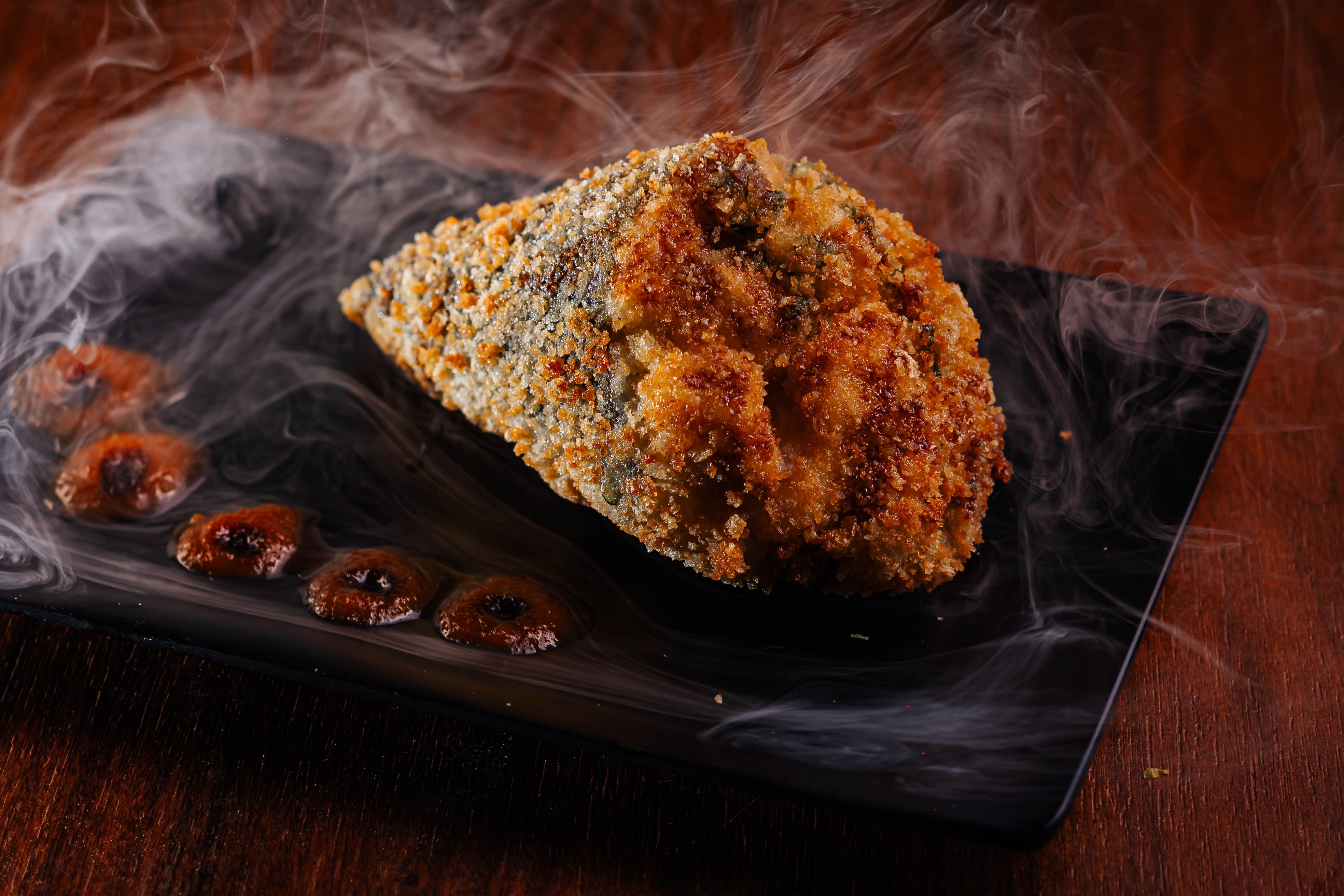 Delicious Smoky Breaded Dish on Dark Plate · Free Stock Photo