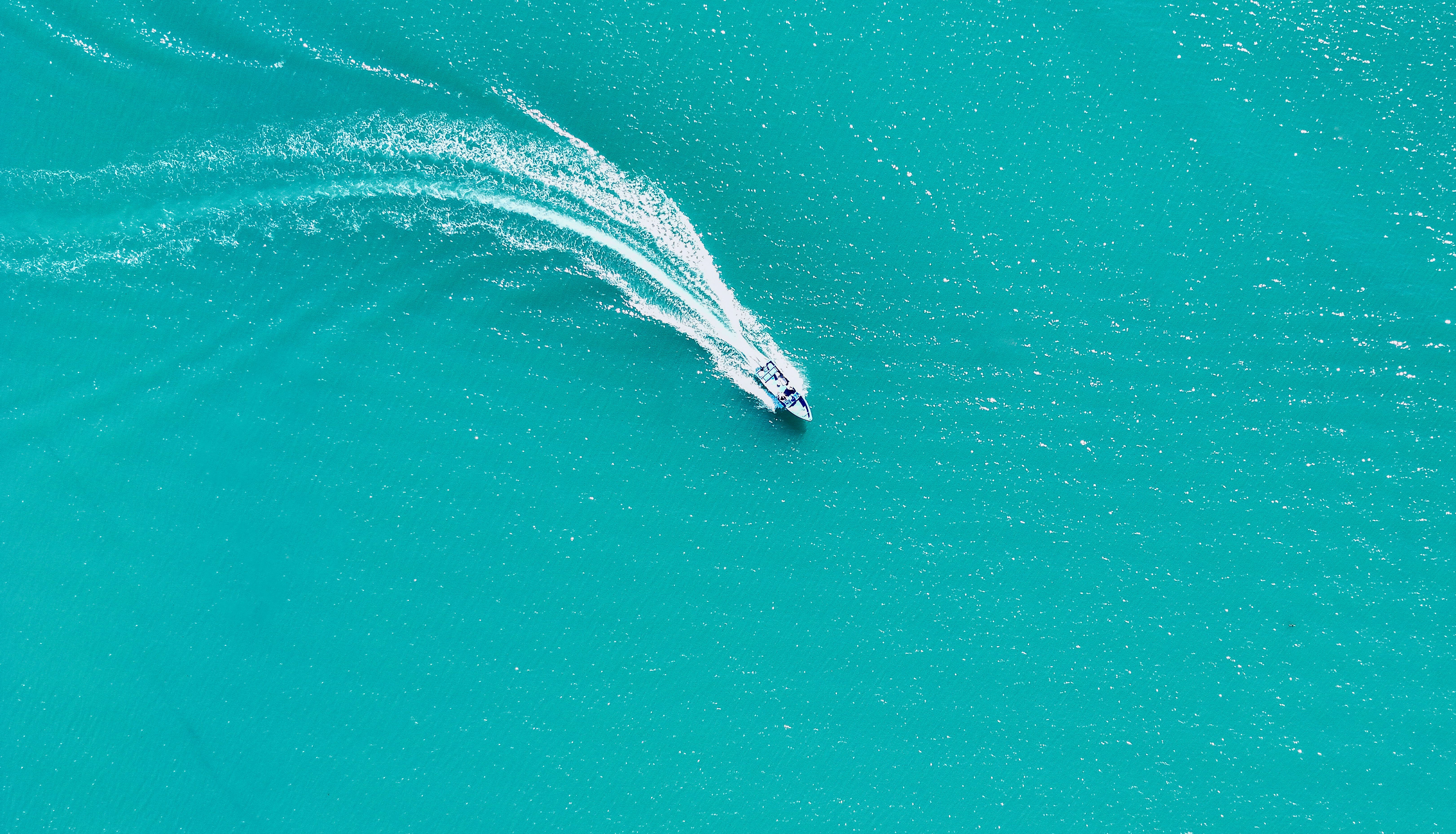 Aerial View of a Speedboat on Tranquil Turquoise Waters · Free Stock Photo