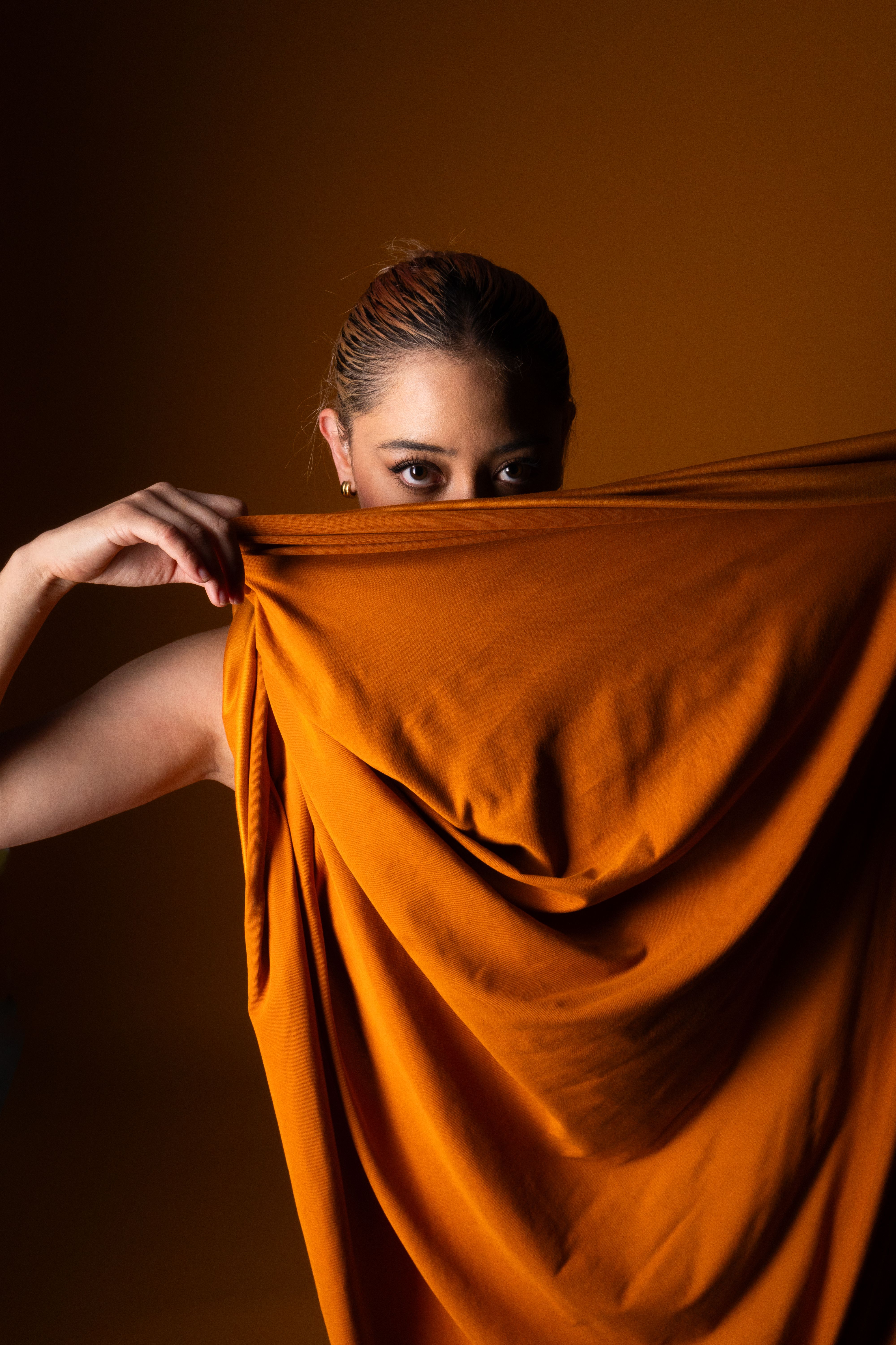 Elegant Woman Draped in Vibrant Orange Fabric · Free Stock Photo