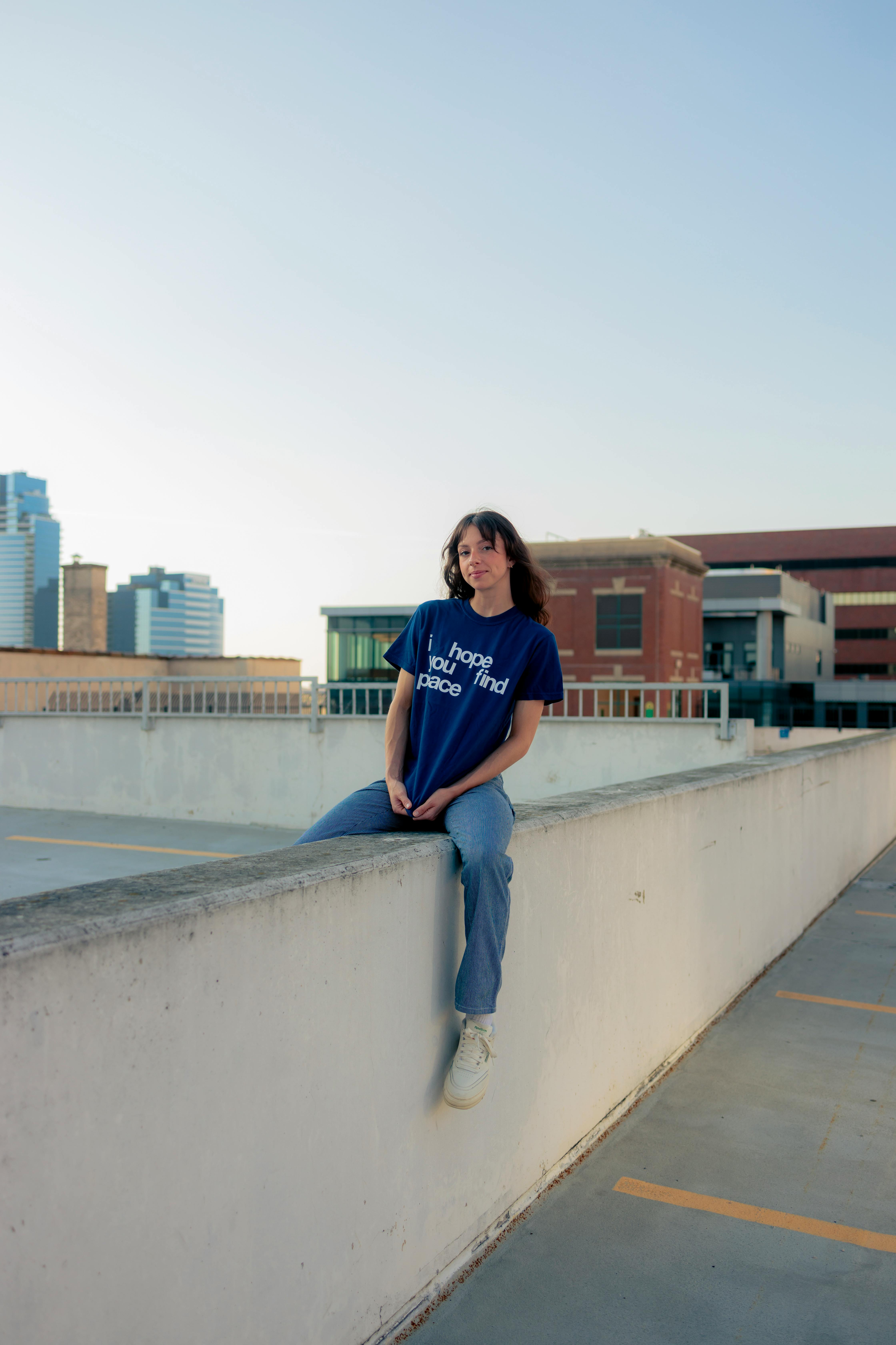 Person Relaxing on Rooftop Edge in Cityscape · Free Stock Photo