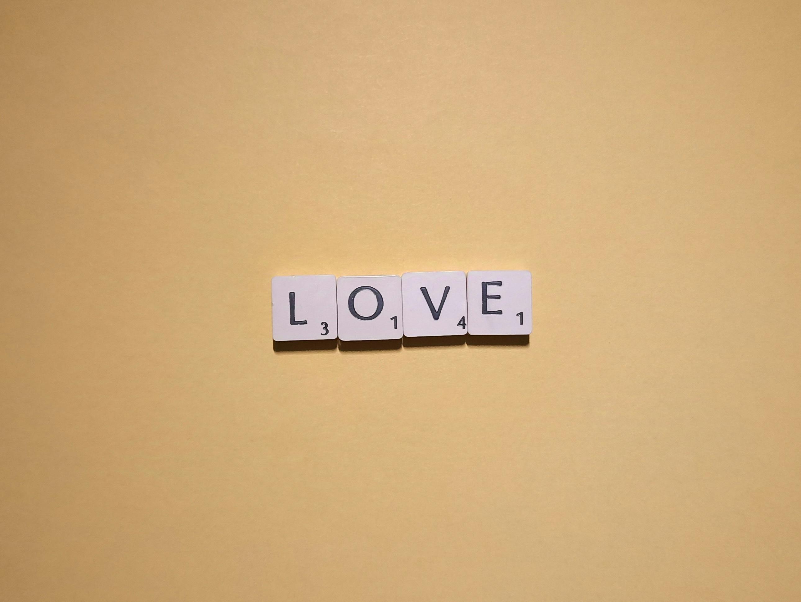 Scrabble Tiles Spelling LOVE on Yellow Background · Free Stock Photo