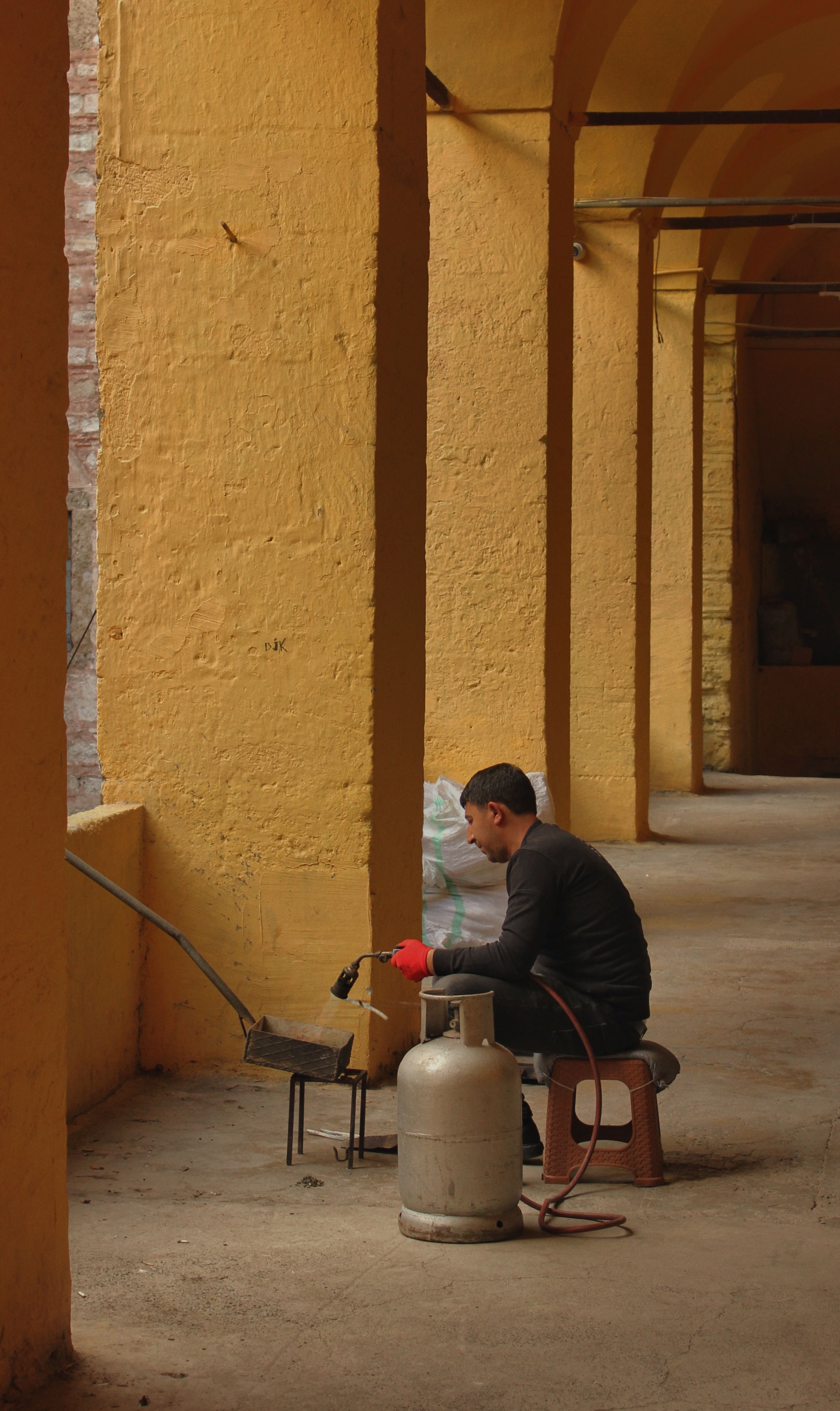 Man working with gas cylinder in yellow hallway · Free Stock Photo