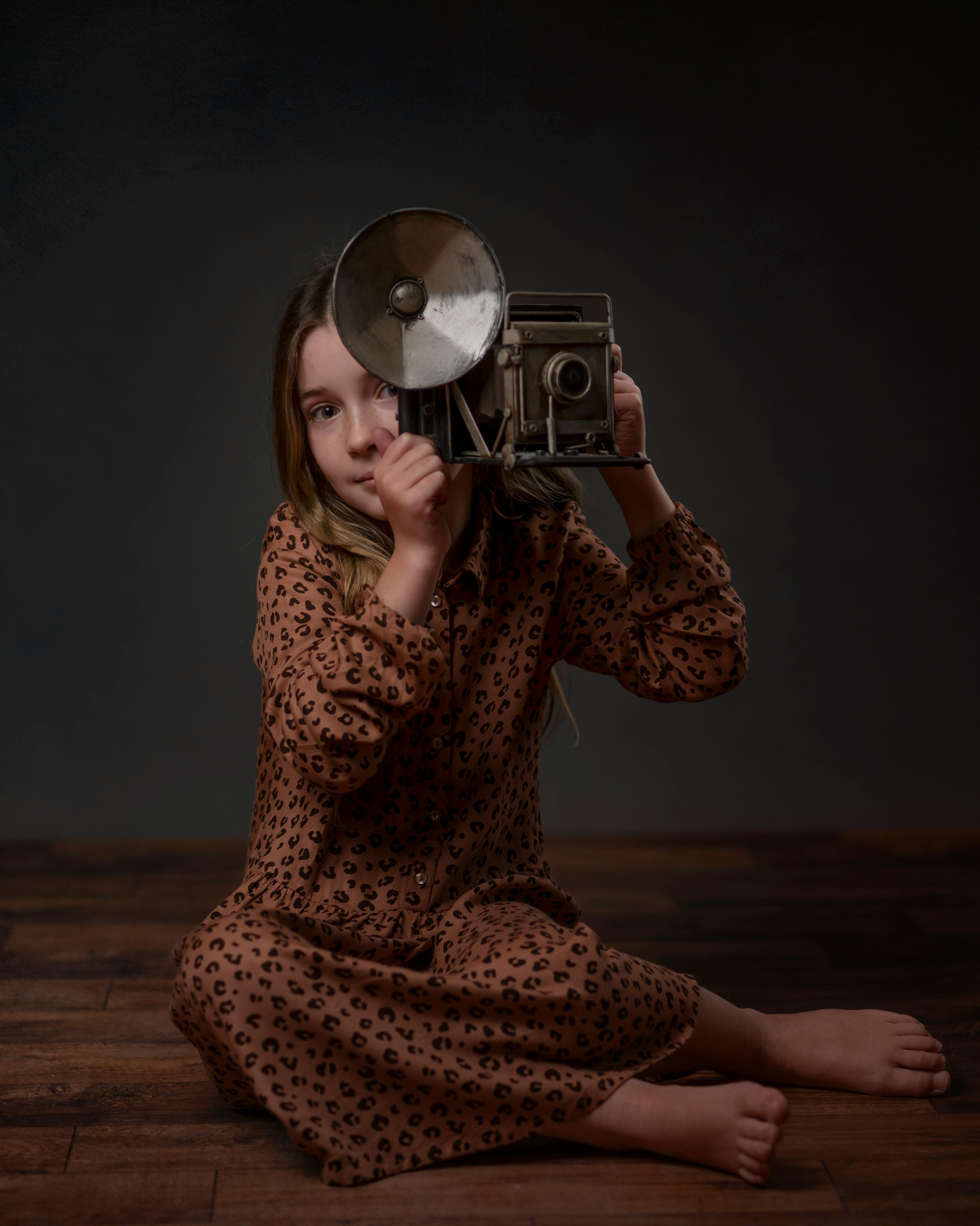 Child Playing with Vintage Camera in Studio Setting · Free Stock Photo