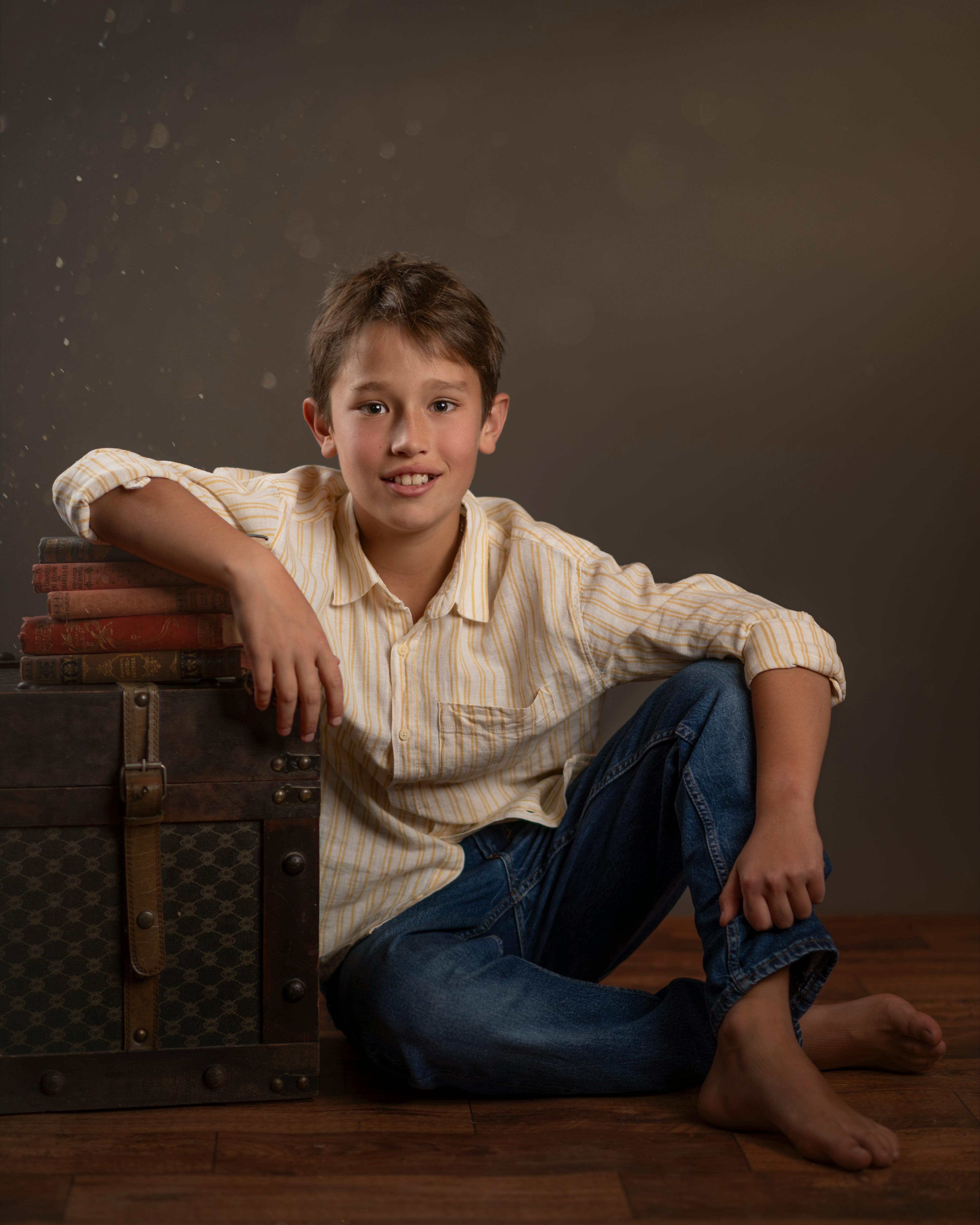 Studio Portrait of a Smiling Young Boy with Books · Free Stock Photo