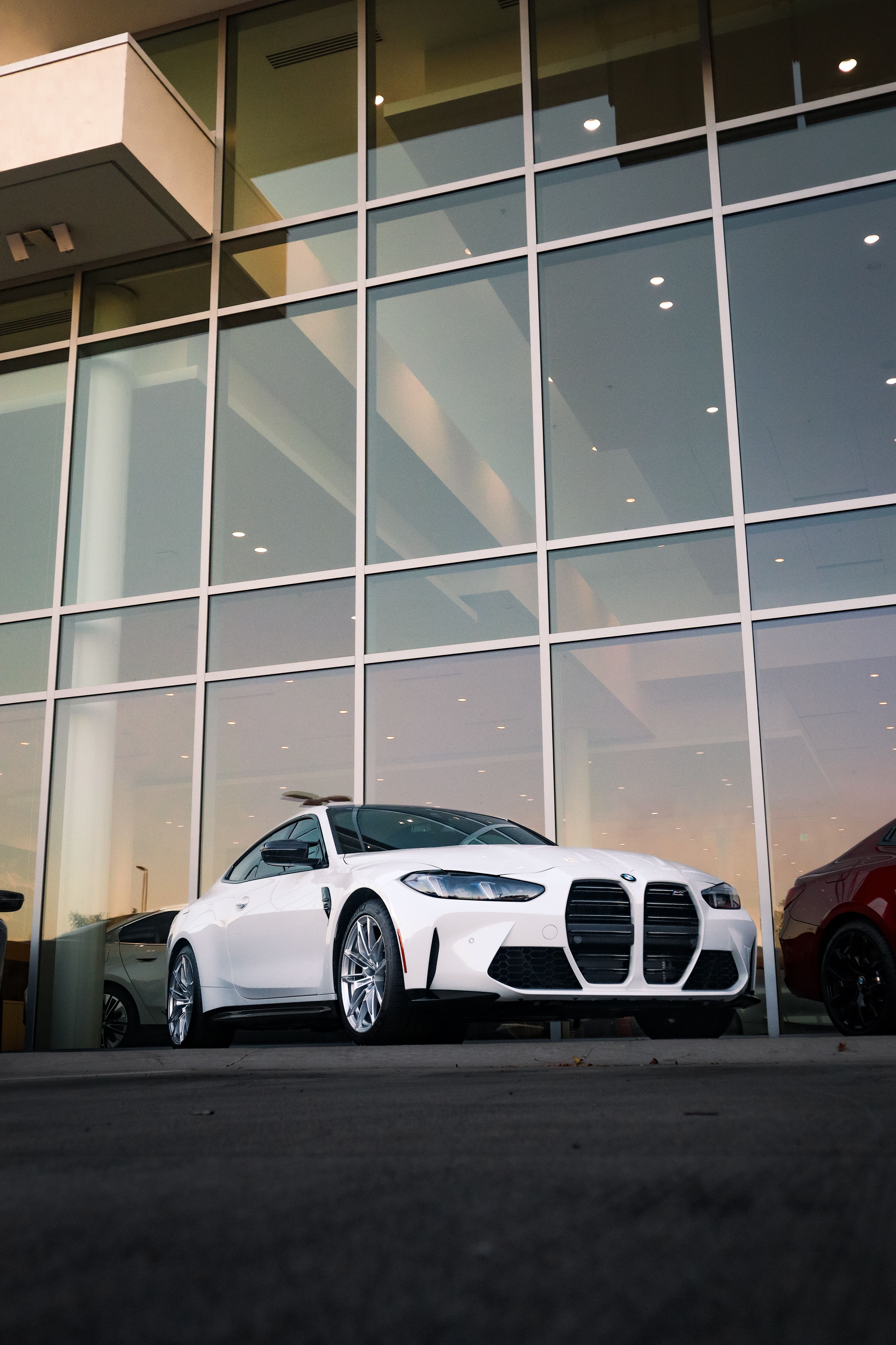Sleek White Car in Front of Modern Glass Building · Free Stock Photo
