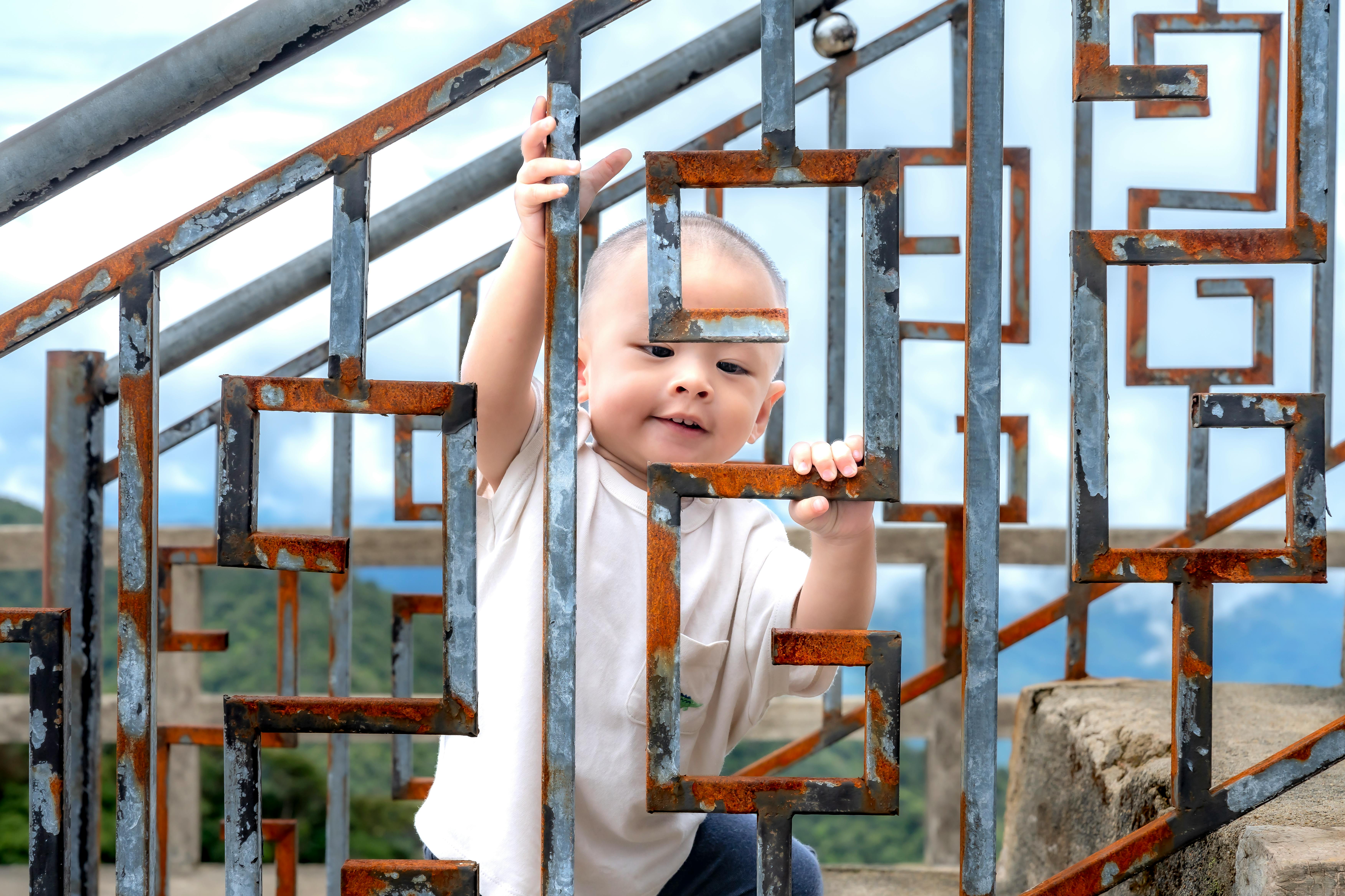 Child Enjoying Outdoor Adventure behind Rustic Fence · Free Stock Photo
