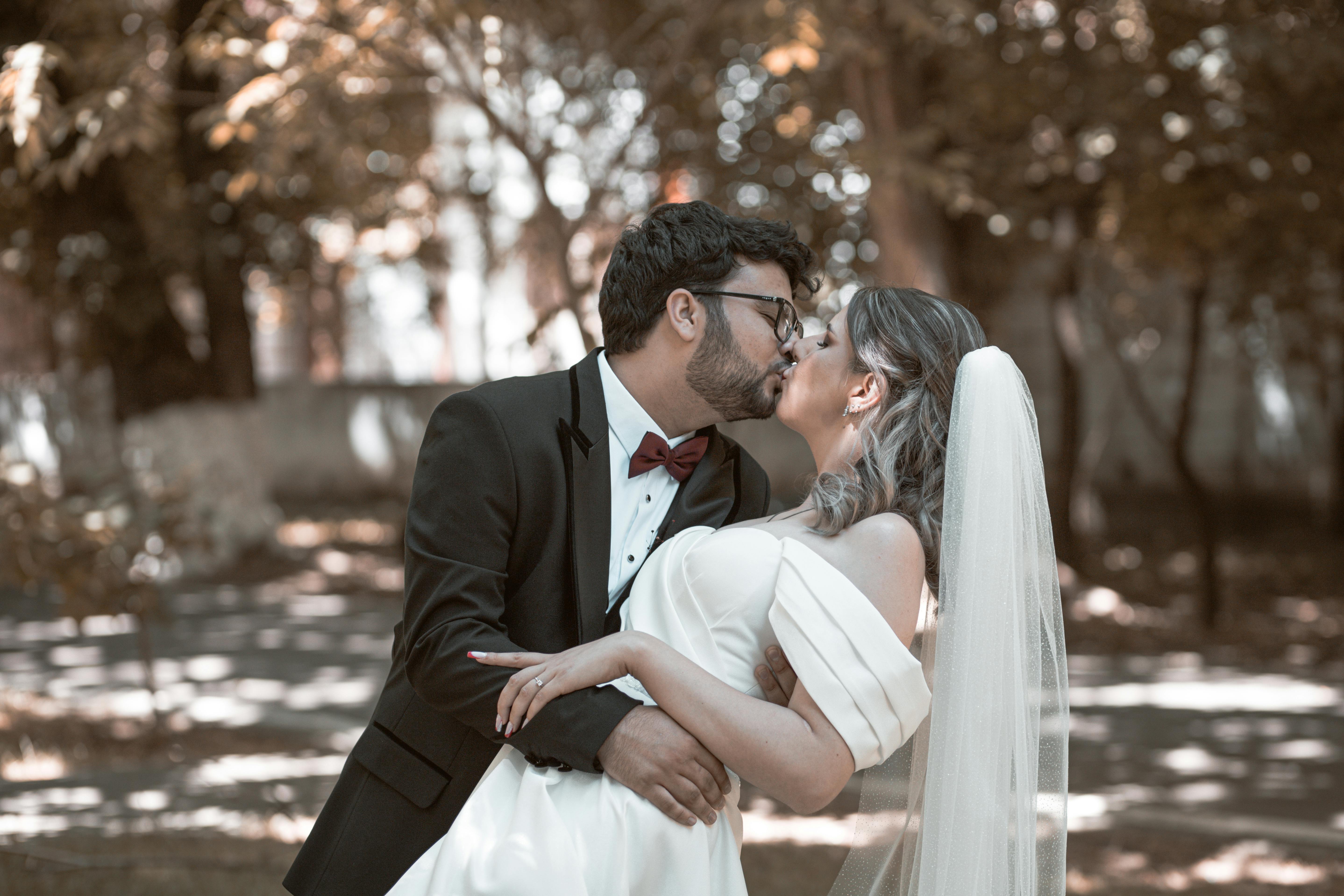 Romantic Wedding Kiss in Park Setting · Free Stock Photo