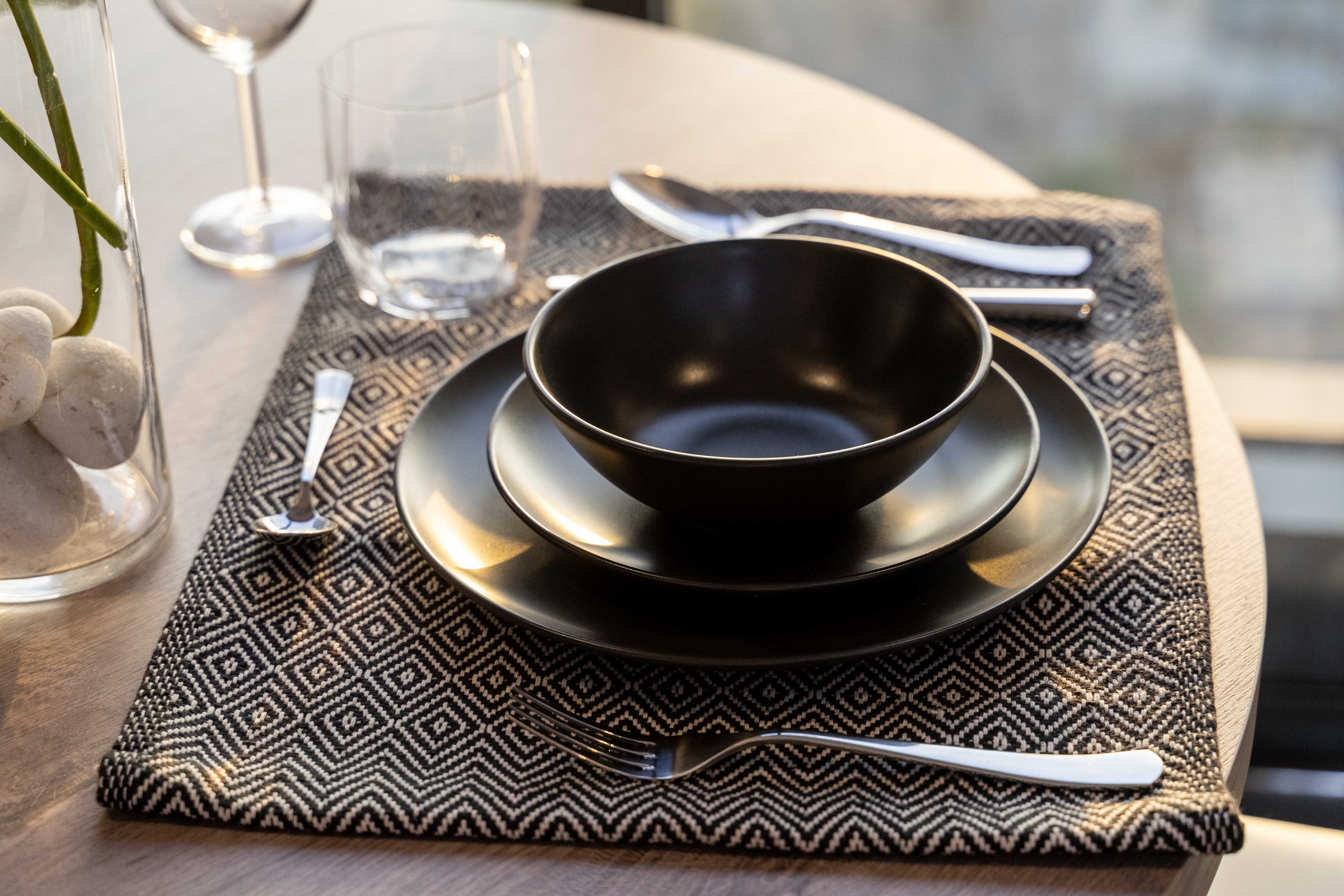 Elegant Black Tableware on Geometric Placemat · Free Stock Photo