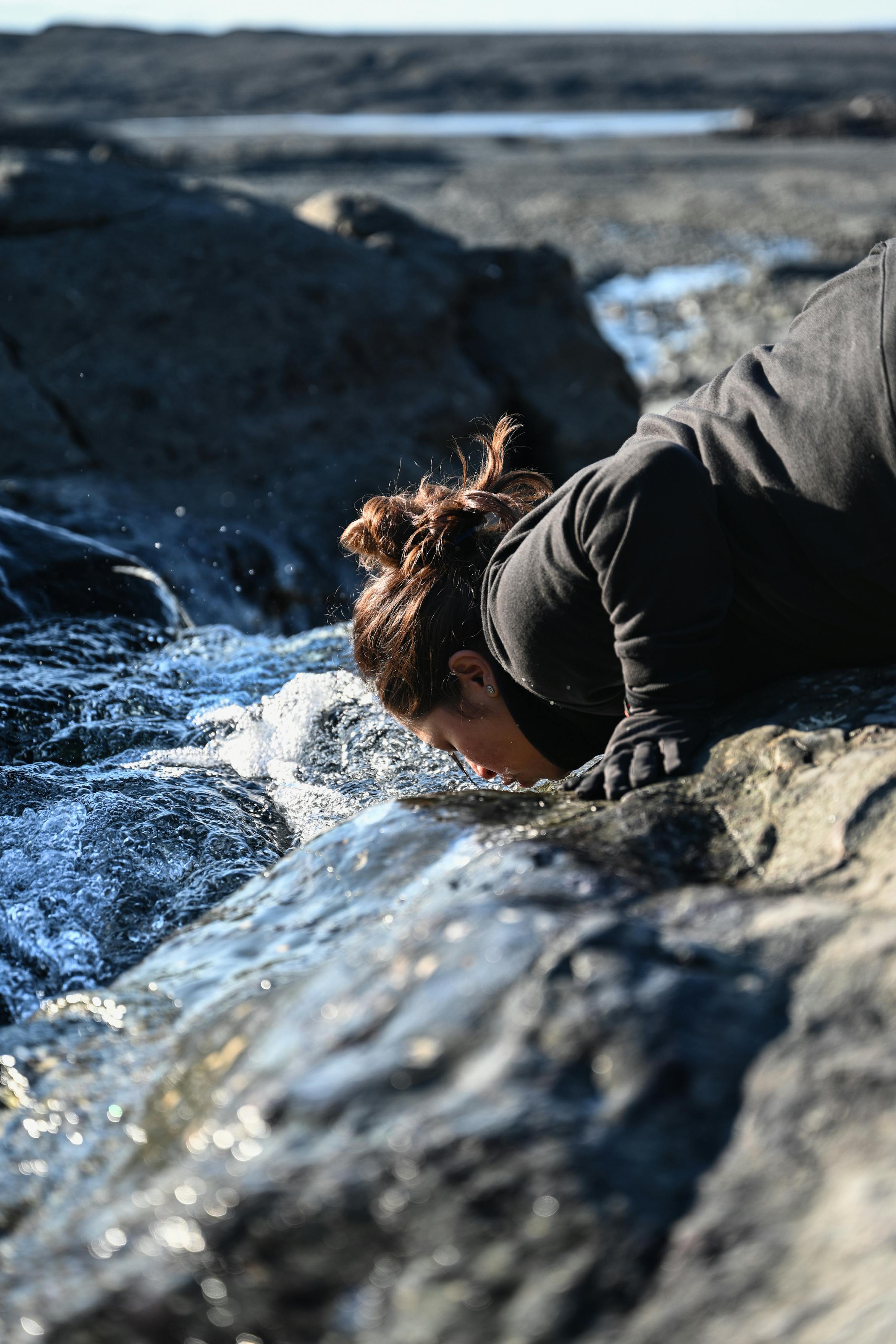 Person Drinking Fresh Water from Icelandic Stream · Free Stock Photo