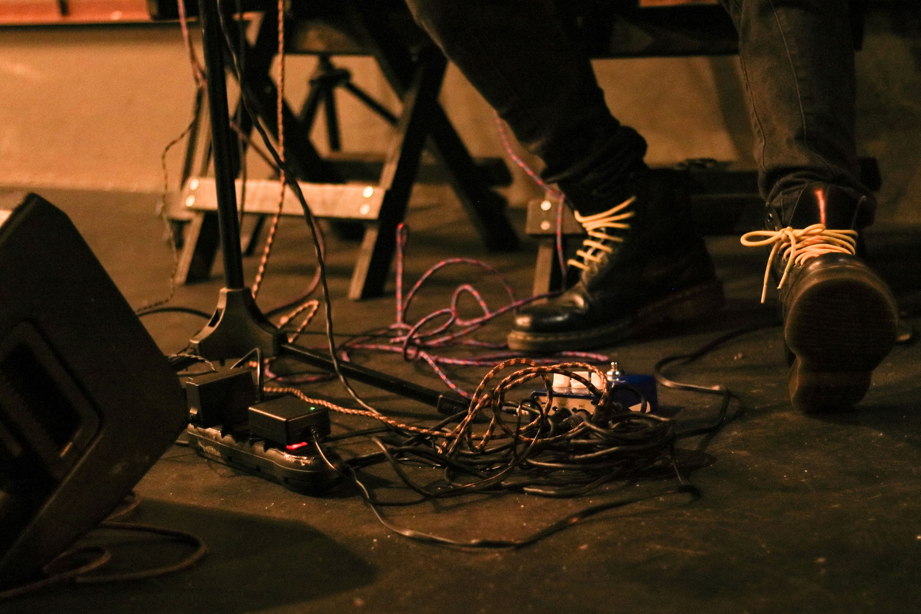 Musician's Feet on Stage with Audio Equipment · Free Stock Photo