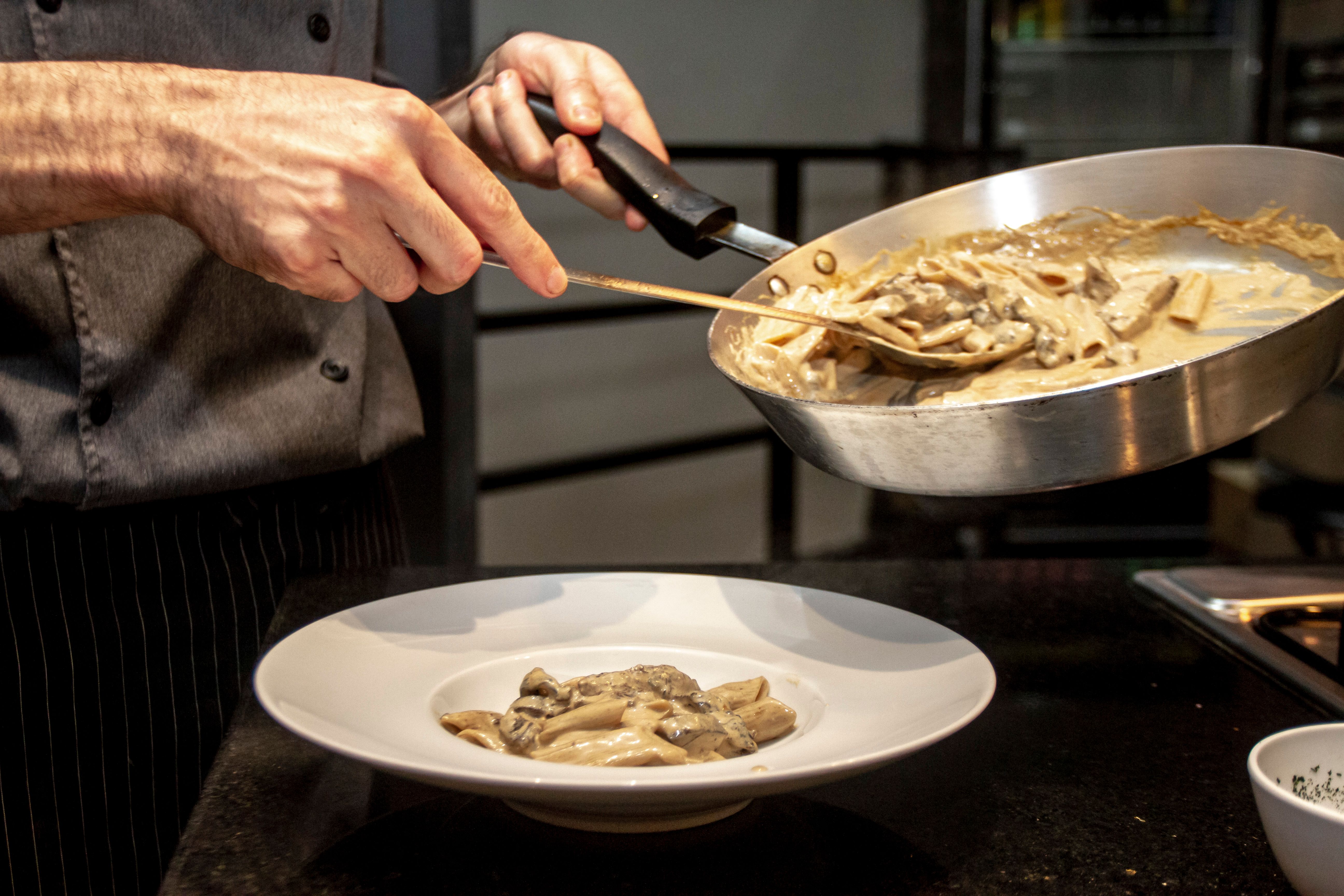 Chef plating creamy mushroom pasta dish · Free Stock Photo