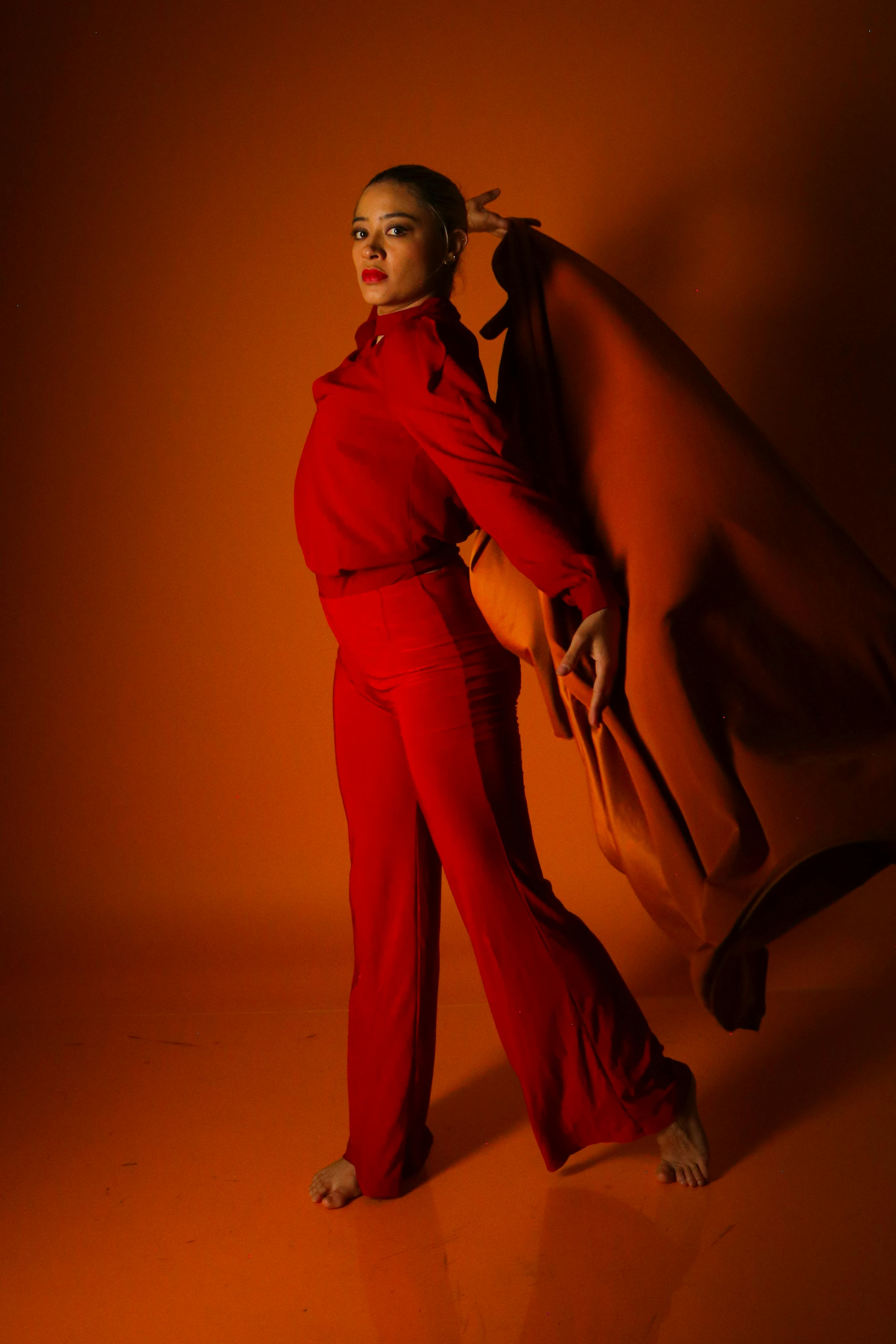 Dynamic Dance Pose in Vibrant Red Outfit · Free Stock Photo