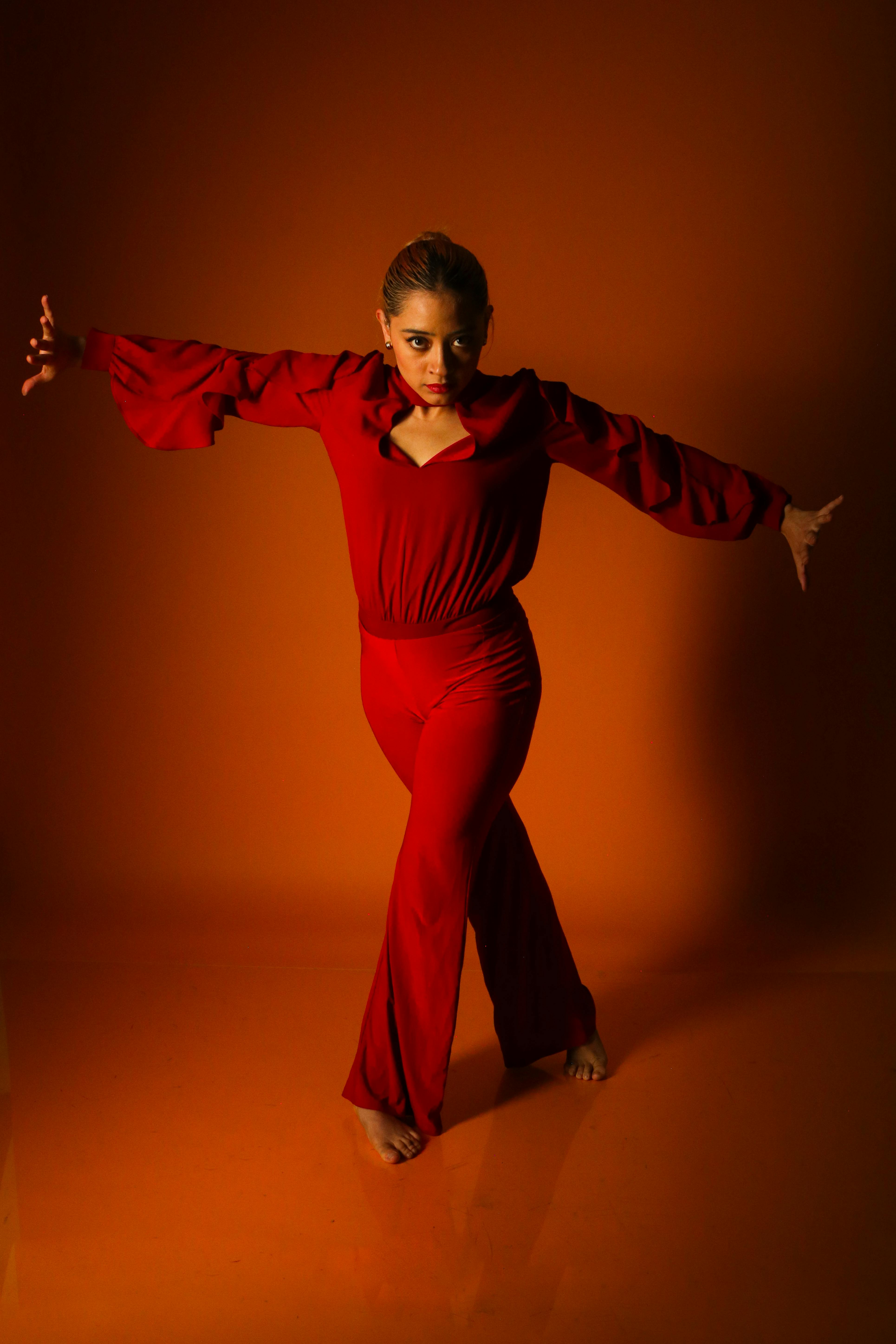 Dynamic Dance Pose in Vibrant Red Outfit · Free Stock Photo