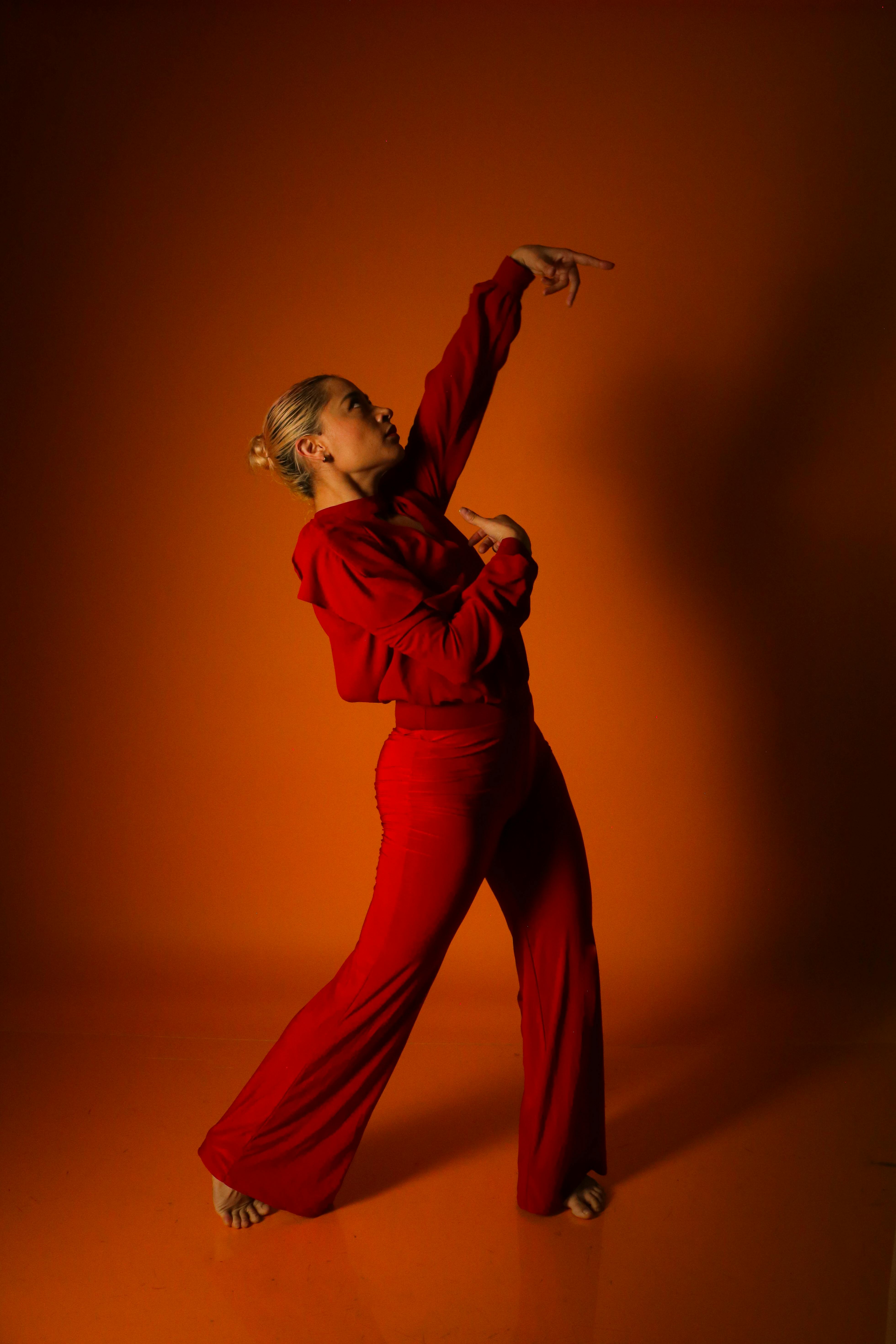 Dynamic Dance Pose in Vibrant Red Outfit · Free Stock Photo