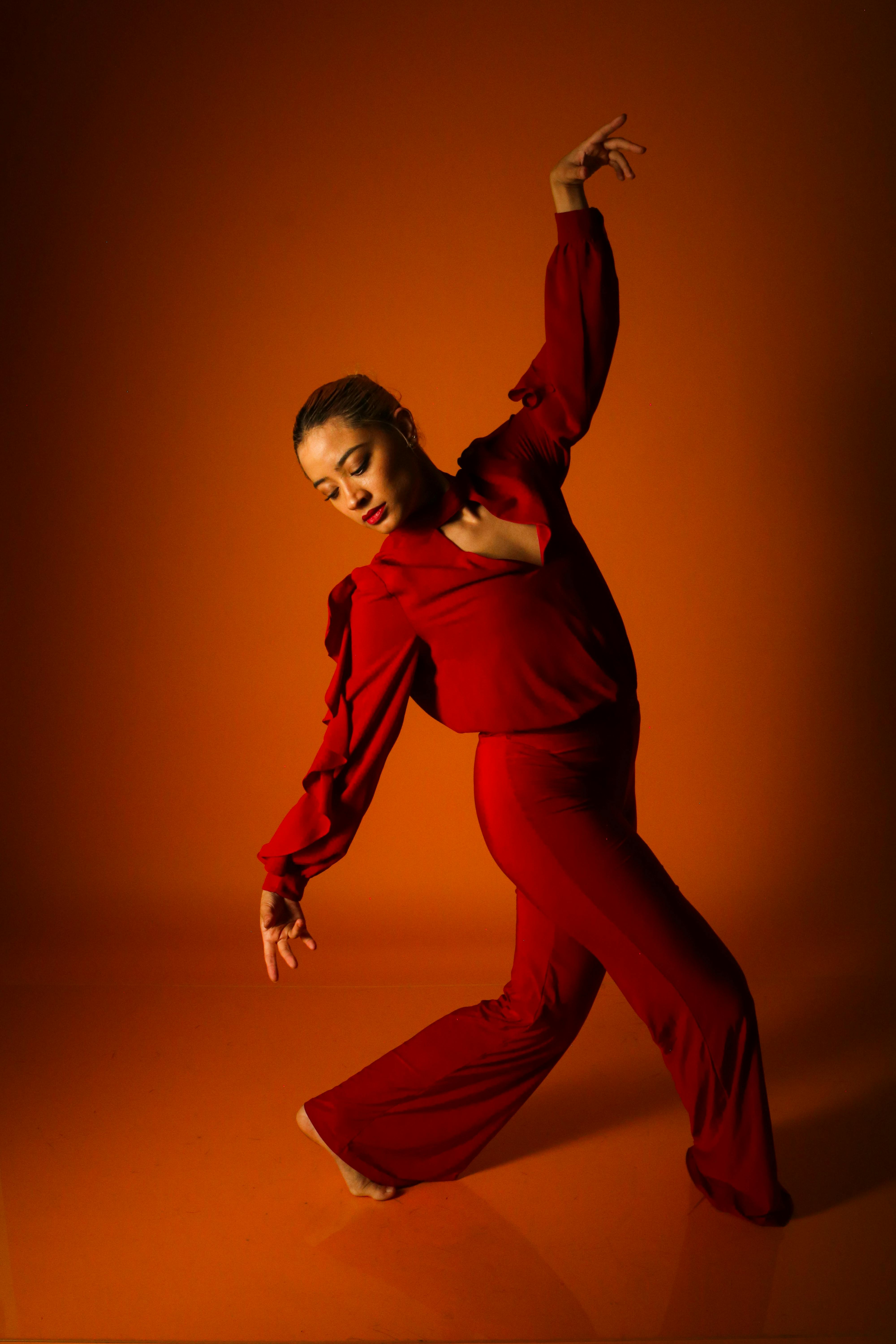 Graceful dancer in red poised on colored background · Free Stock Photo