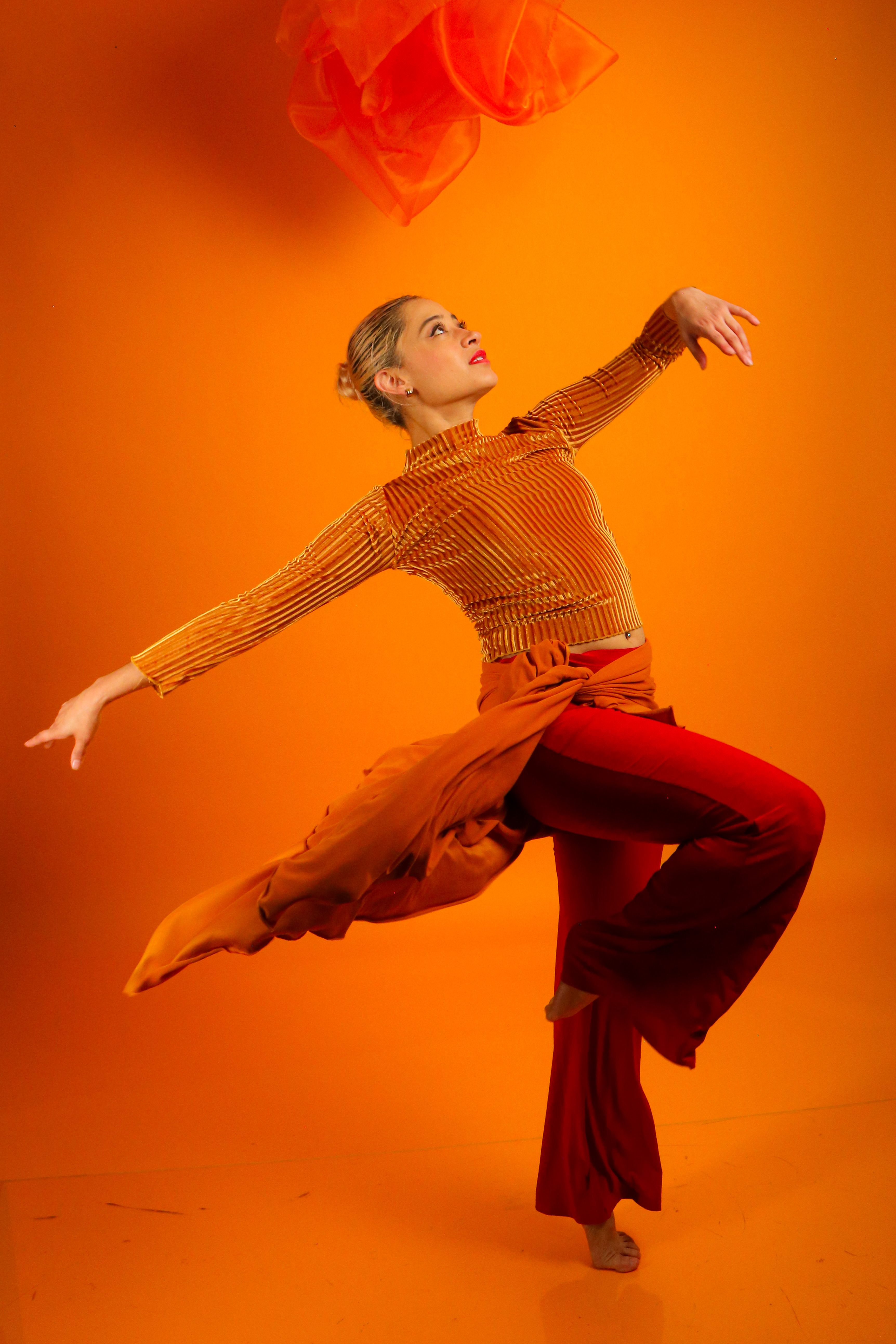 Expressive Modern Dance in Vibrant Orange Studio · Free Stock Photo