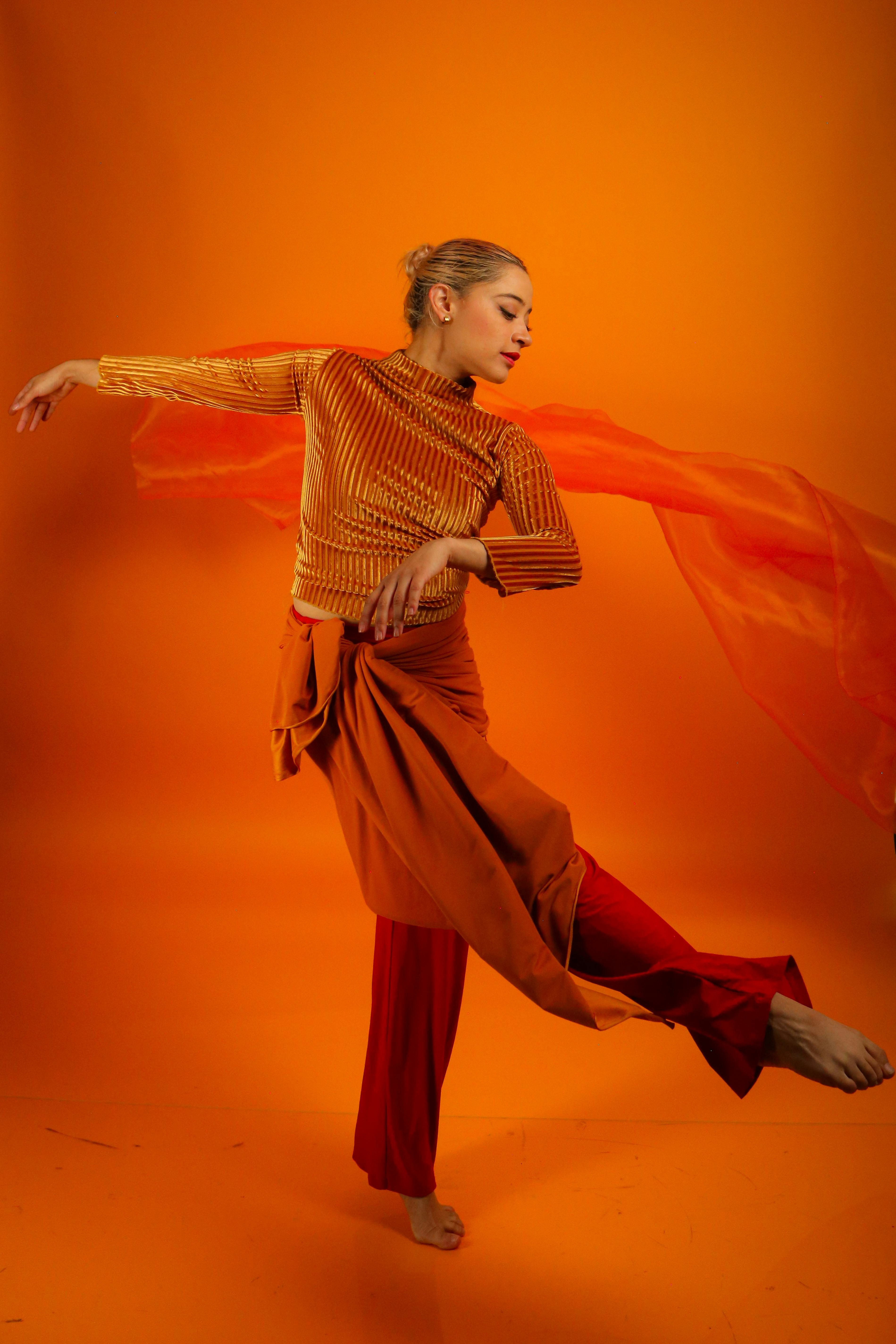 Expressive Dancer in Vibrant Orange Attire · Free Stock Photo