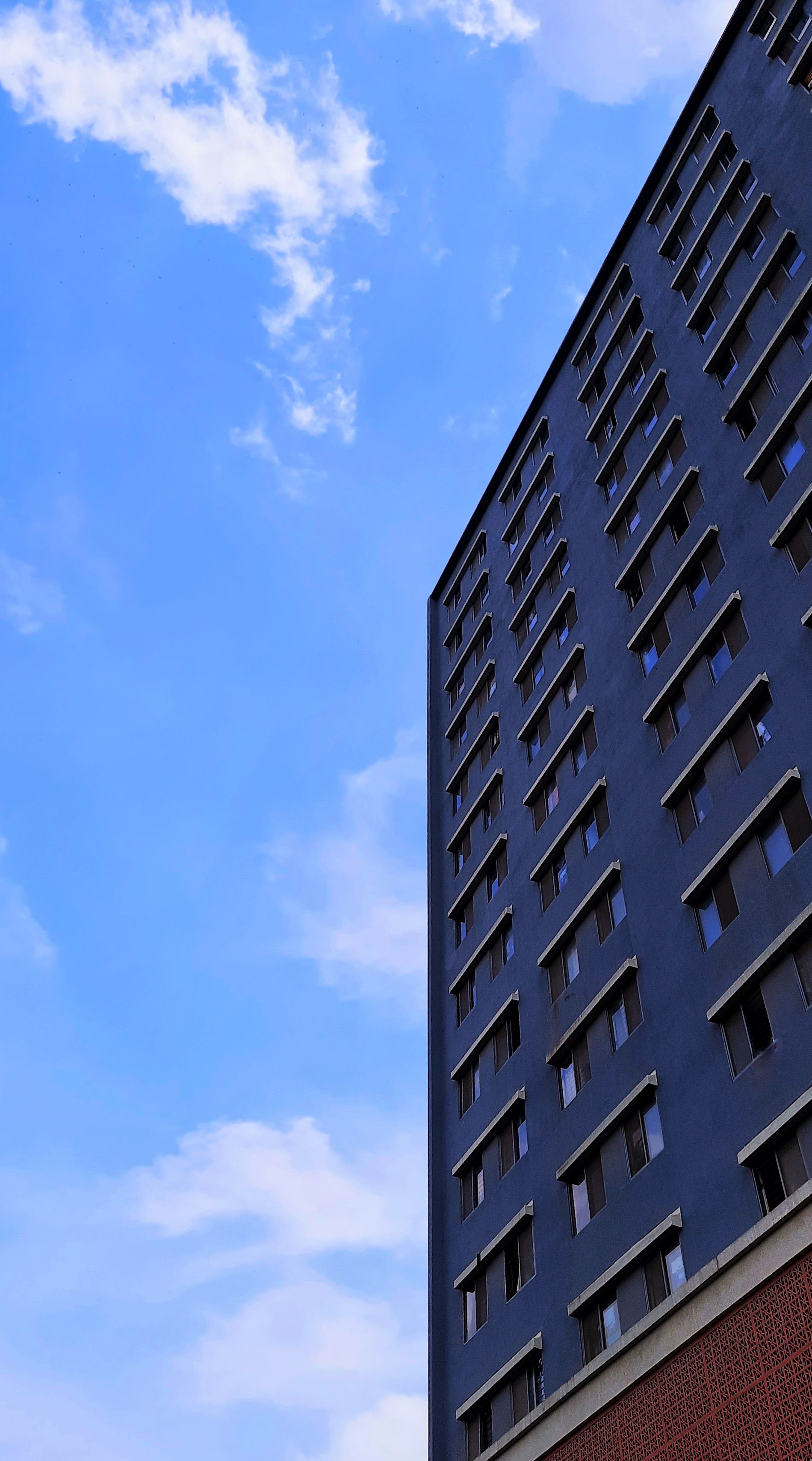 Modern Skyscraper Against a Clear Blue Sky · Free Stock Photo