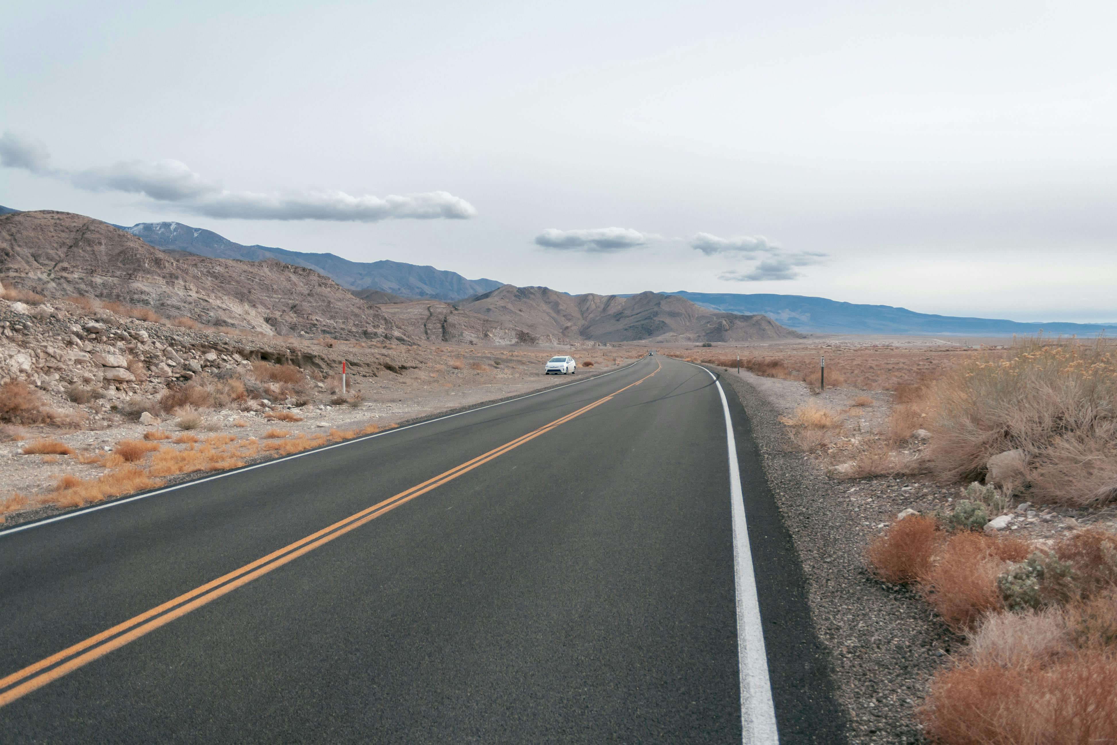 Empty Gray Road Under White Clouds · Free Stock Photo