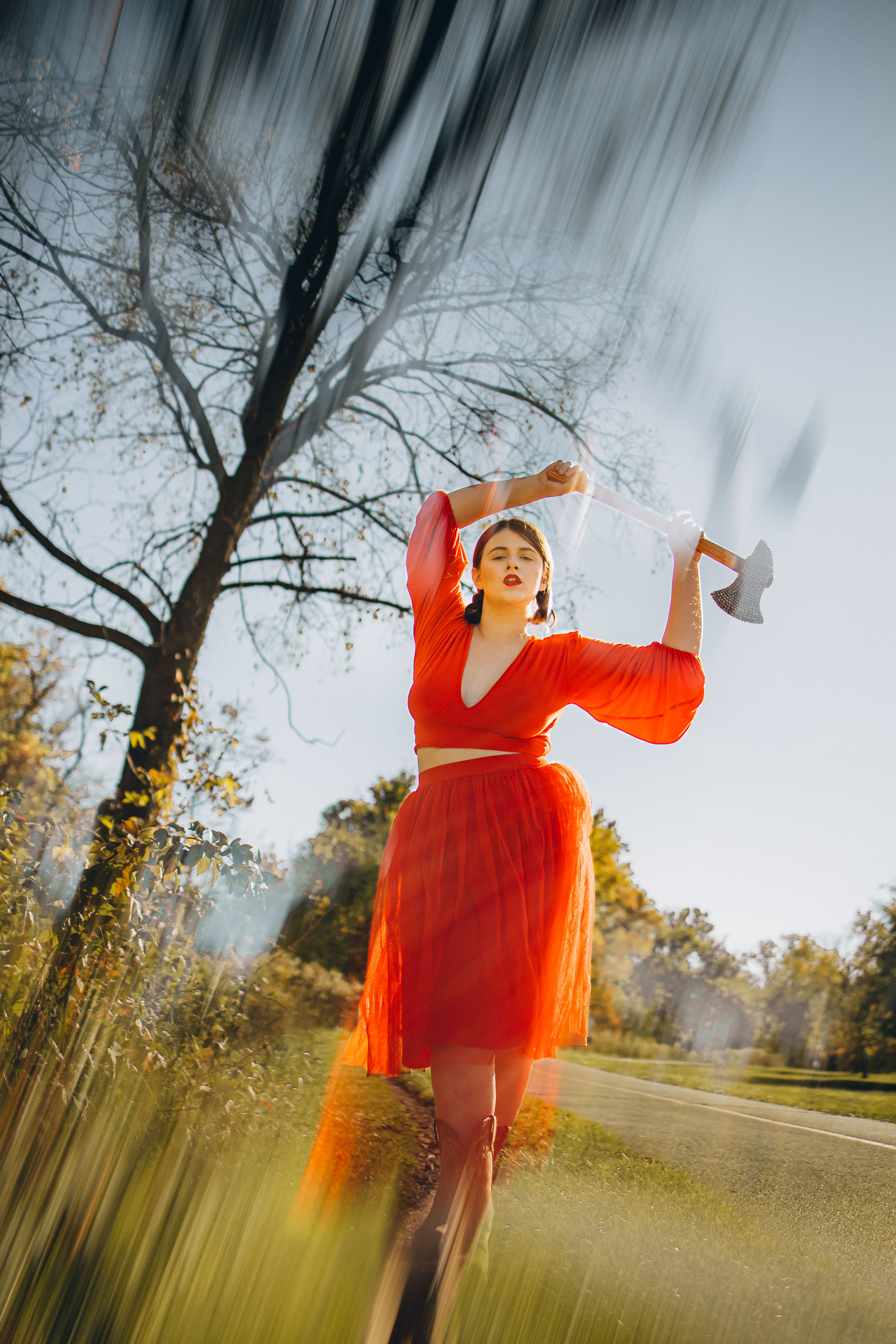 Woman in Red Dress Wielding Axe Outdoors · Free Stock Photo