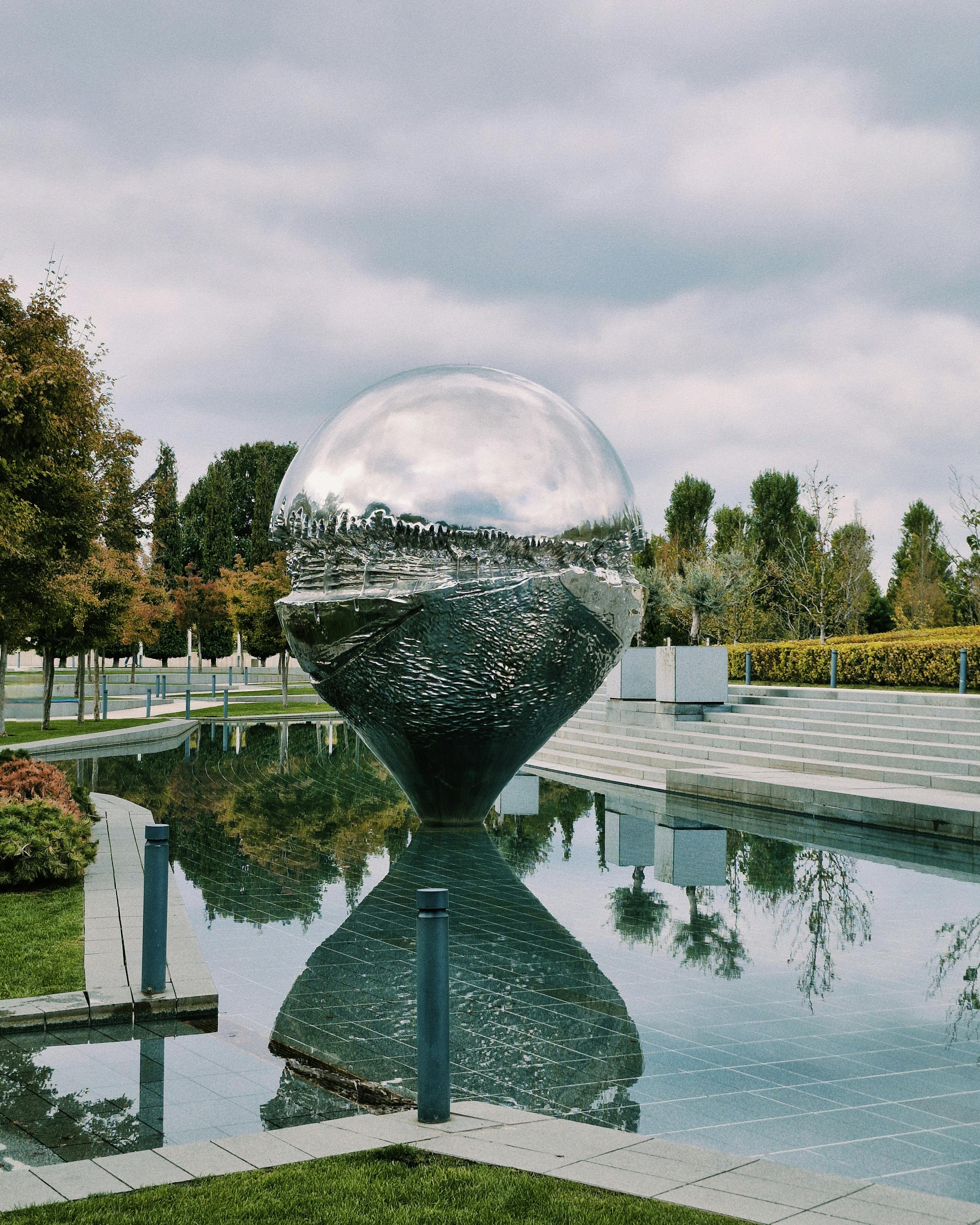 Reflective Sphere Sculpture in Tranquil Park · Free Stock Photo