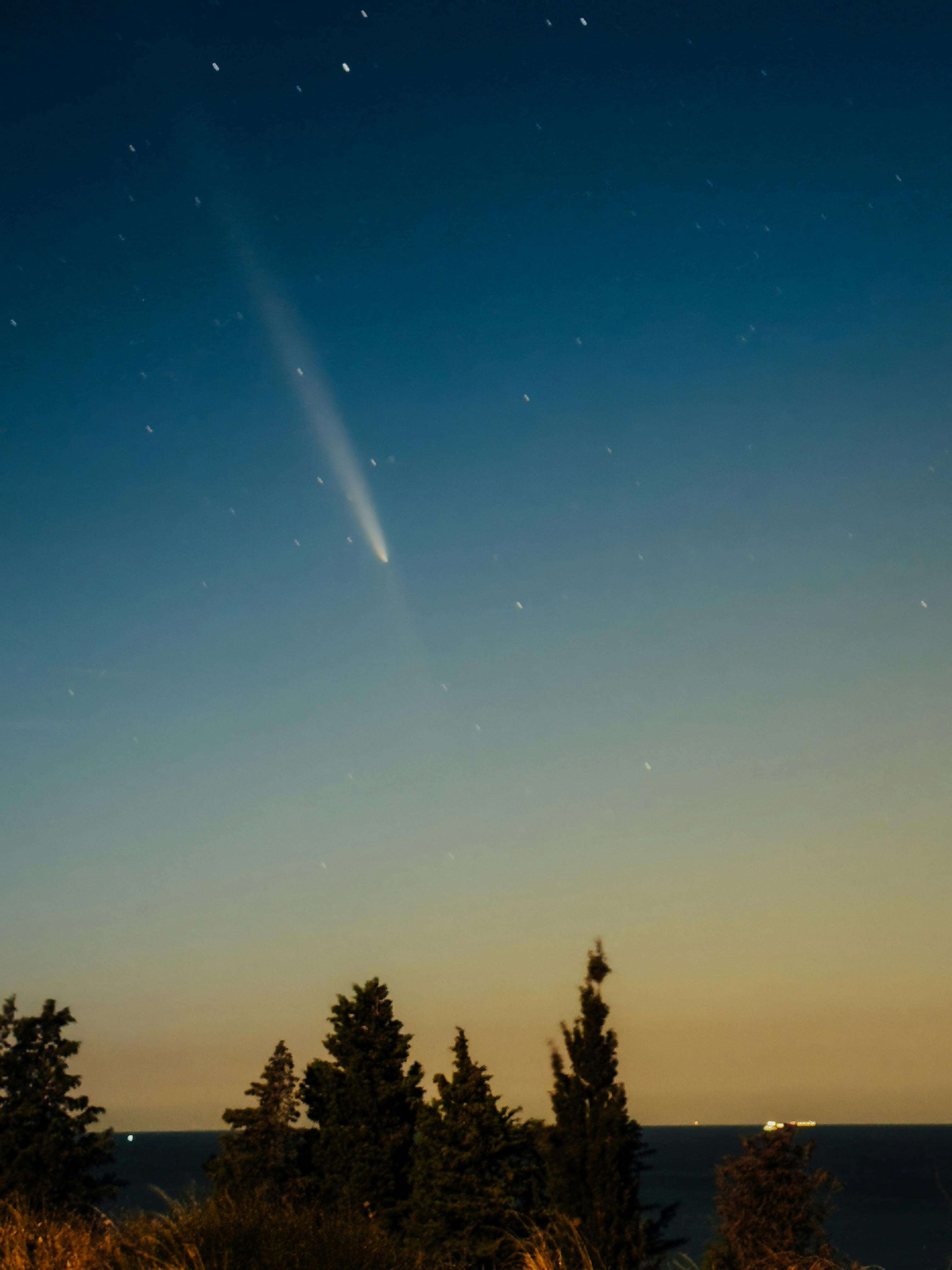 Comet Streaking Across Starry Sky Over Landscape · Free Stock Photo