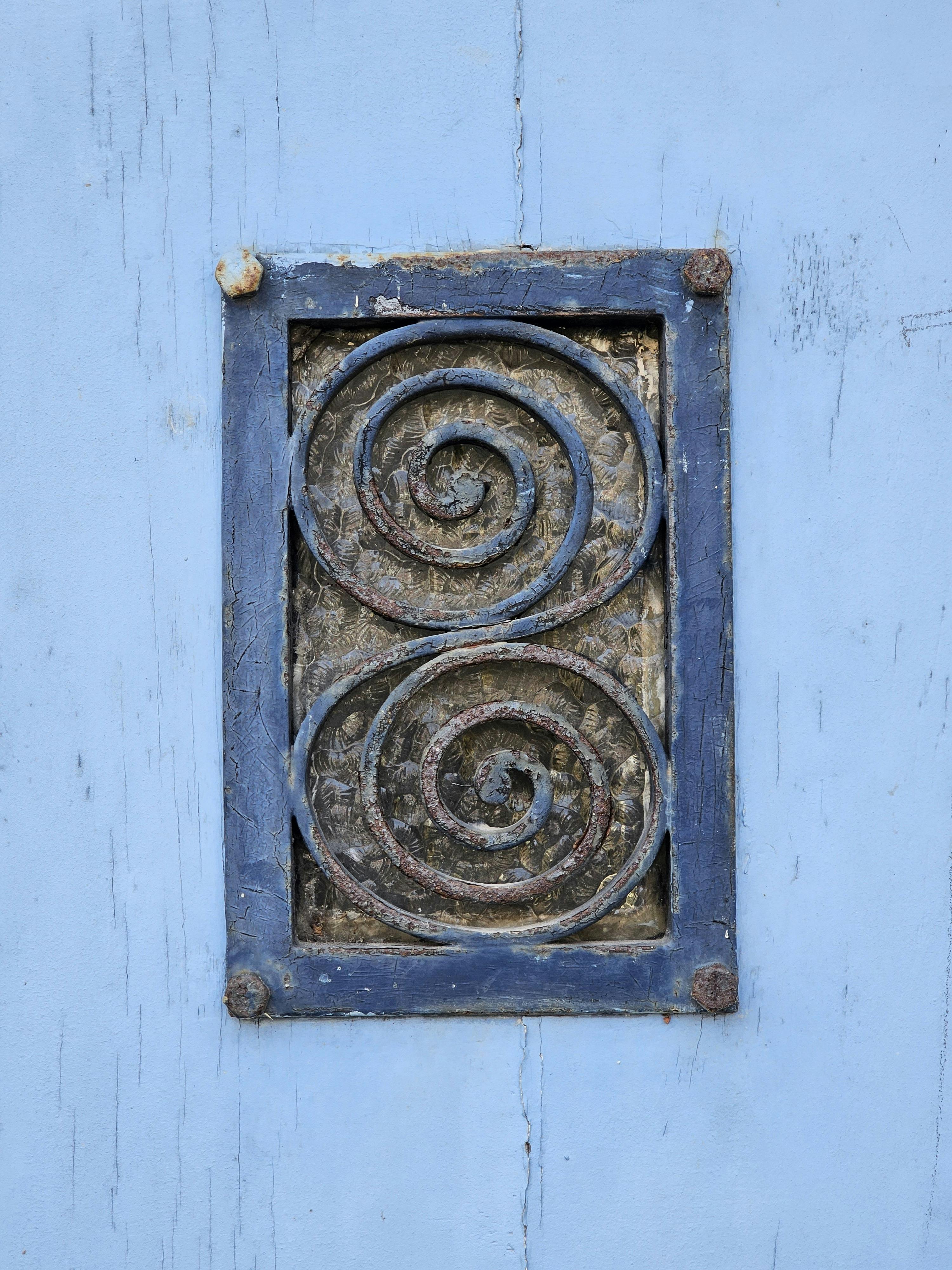 Rustic Blue Spiral Metal Grate on Weathered Door · Free Stock Photo