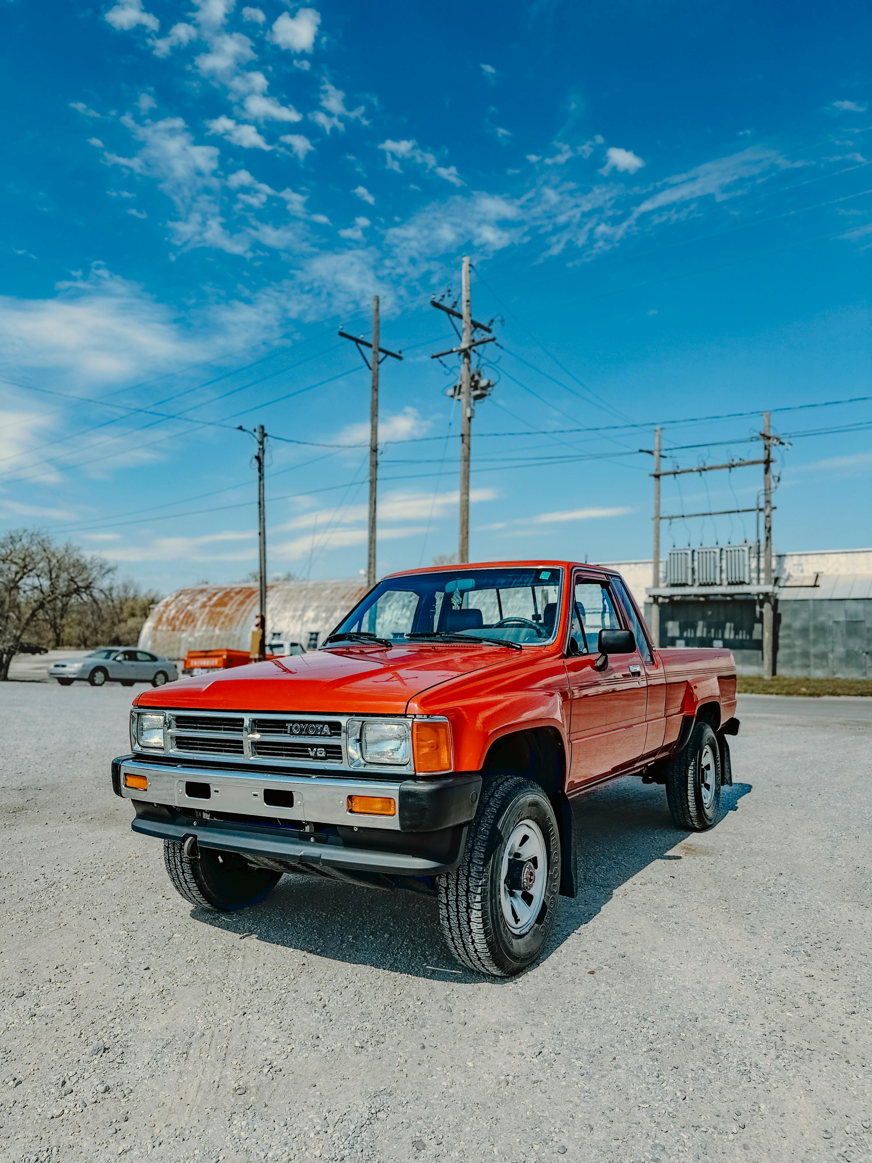 Red Toyota Pickup Truck in Industrial Landscape · Free Stock Photo