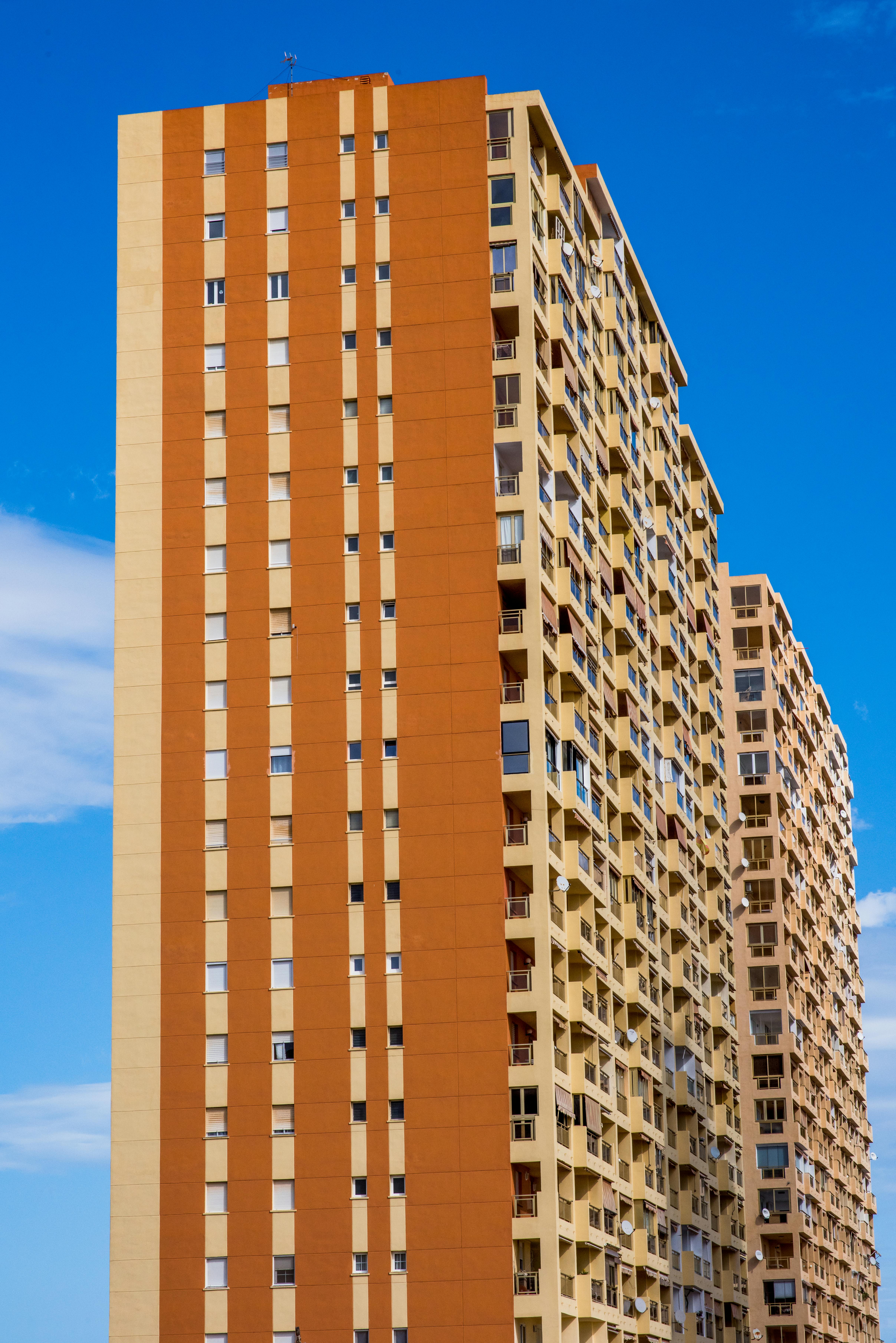 Tall Residential Building Against Blue Sky · Free Stock Photo