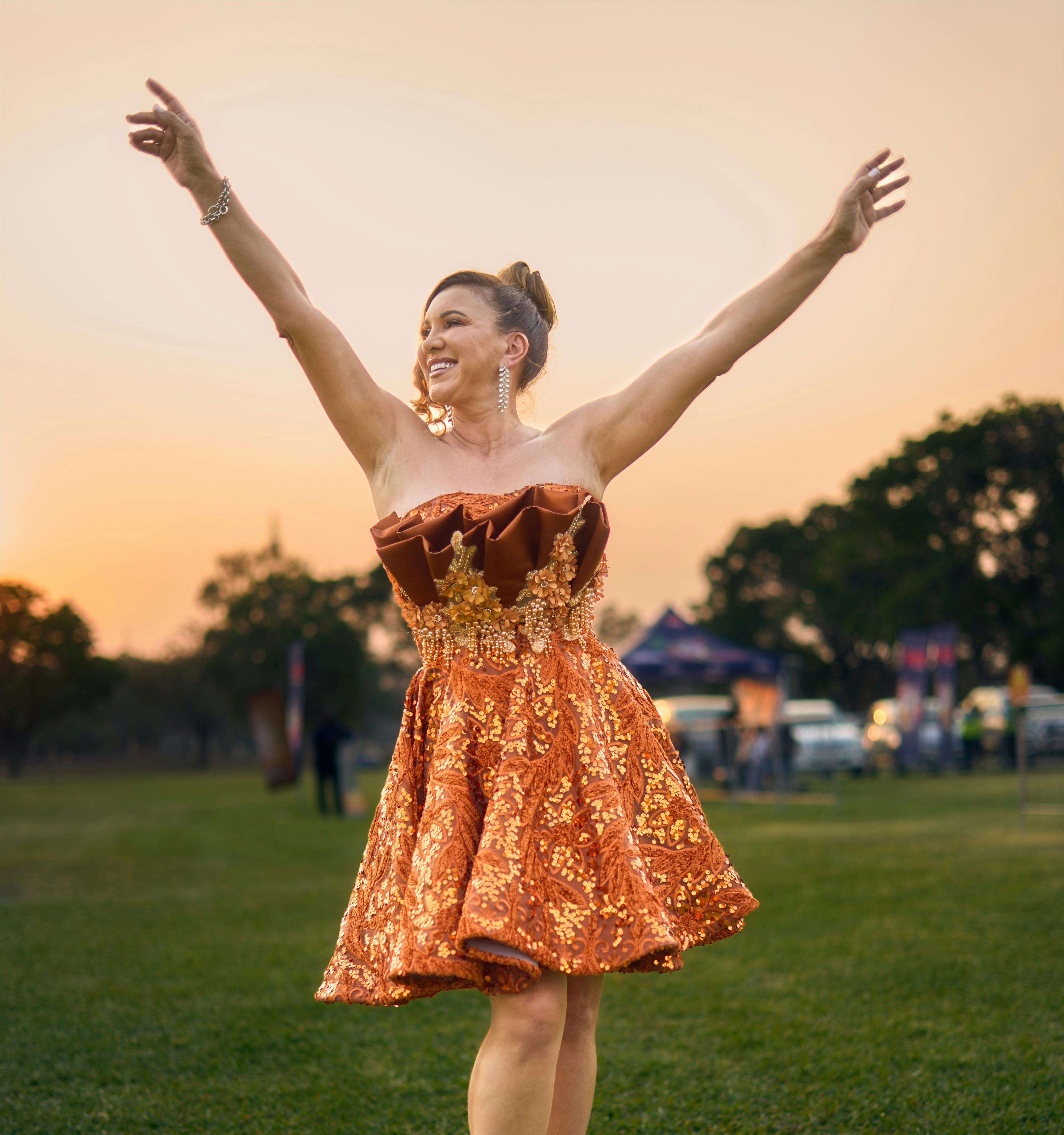 Joyful Dance at Sunset in Elegant Dress · Free Stock Photo