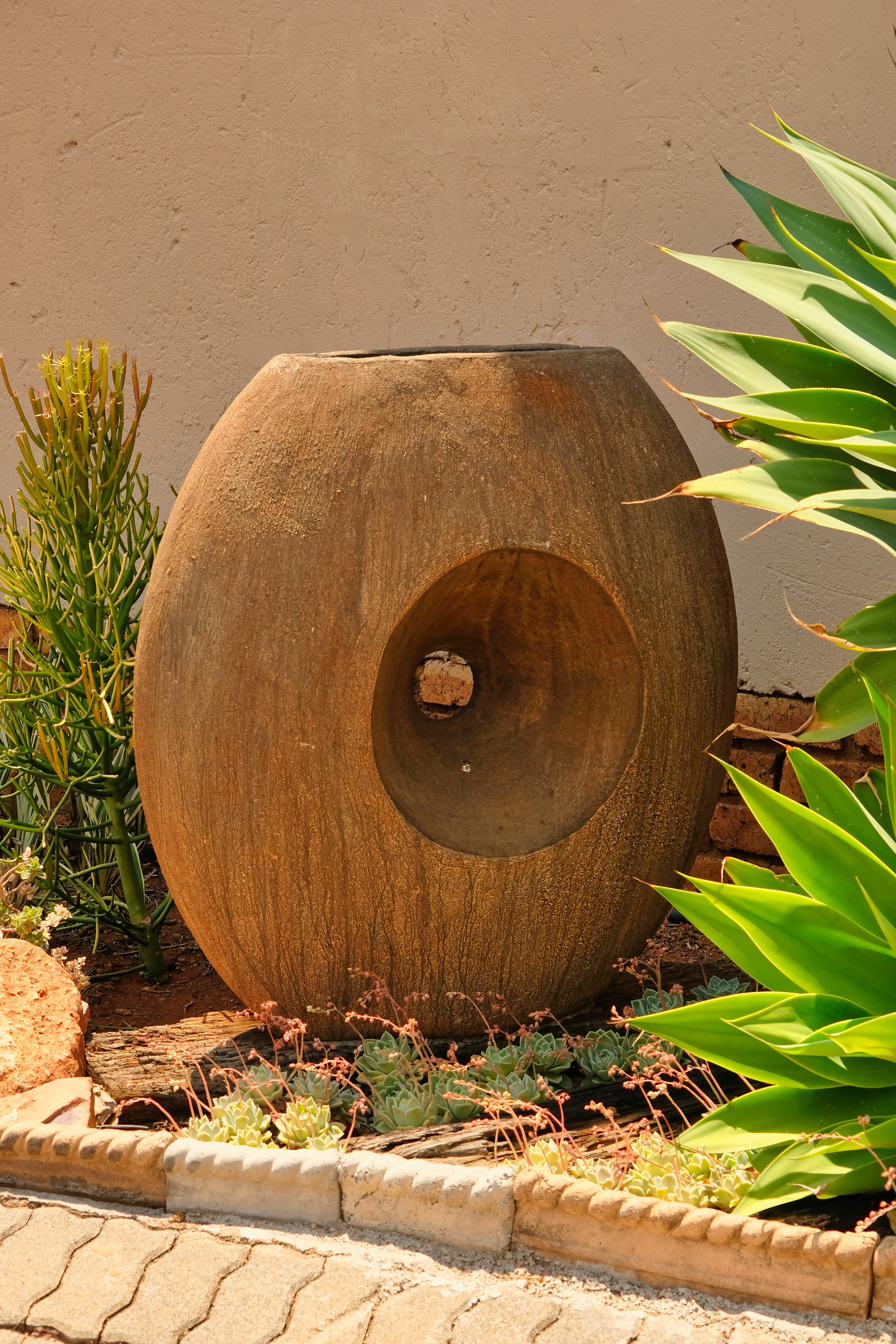 Rustic Garden Stone Sculpture Among Green Plants · Free Stock Photo
