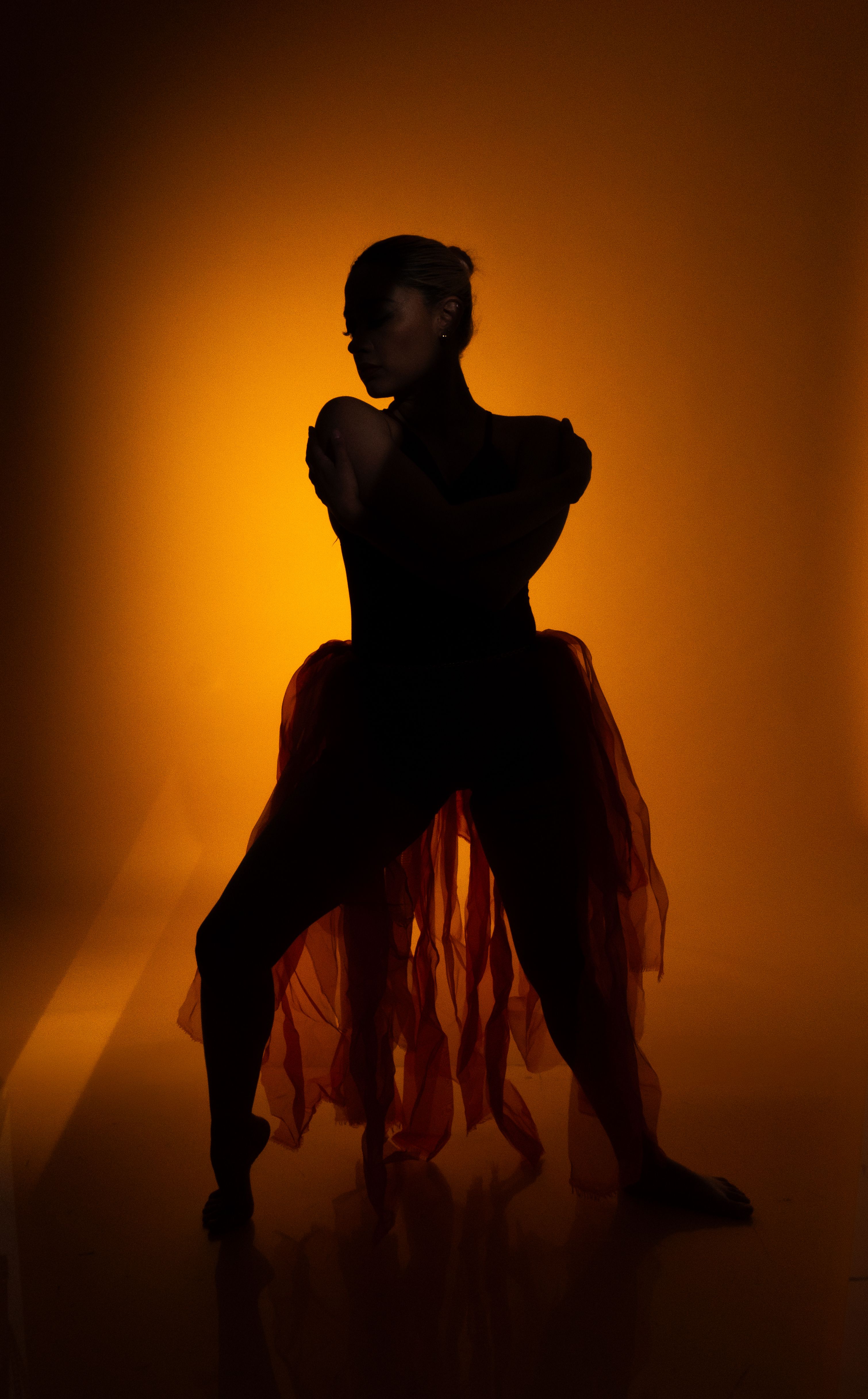 Silhouette of Dancer Against Orange Backdrop · Free Stock Photo