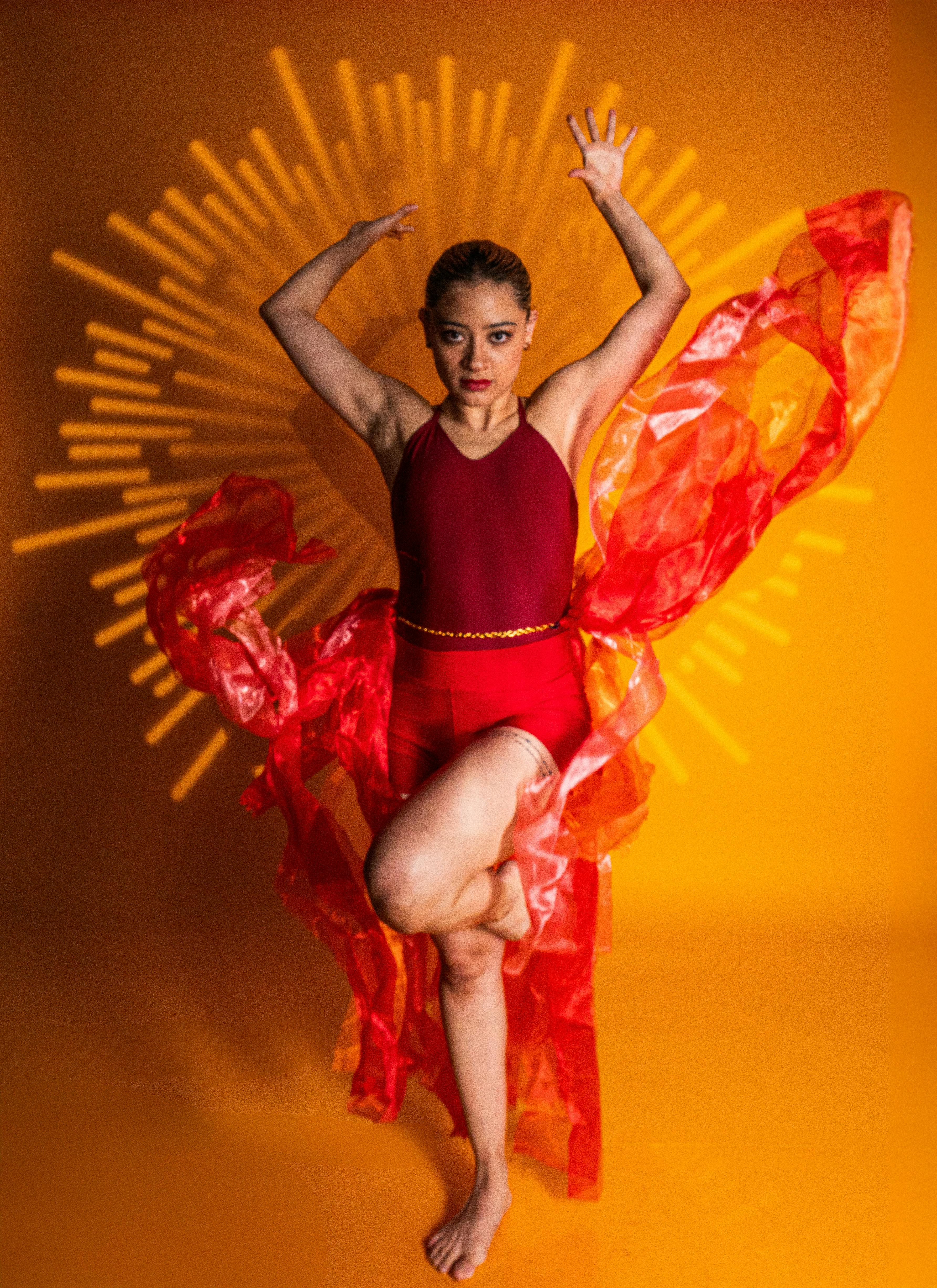 Dynamic Latina Dancer in Red with Orange Spotlight · Free Stock Photo