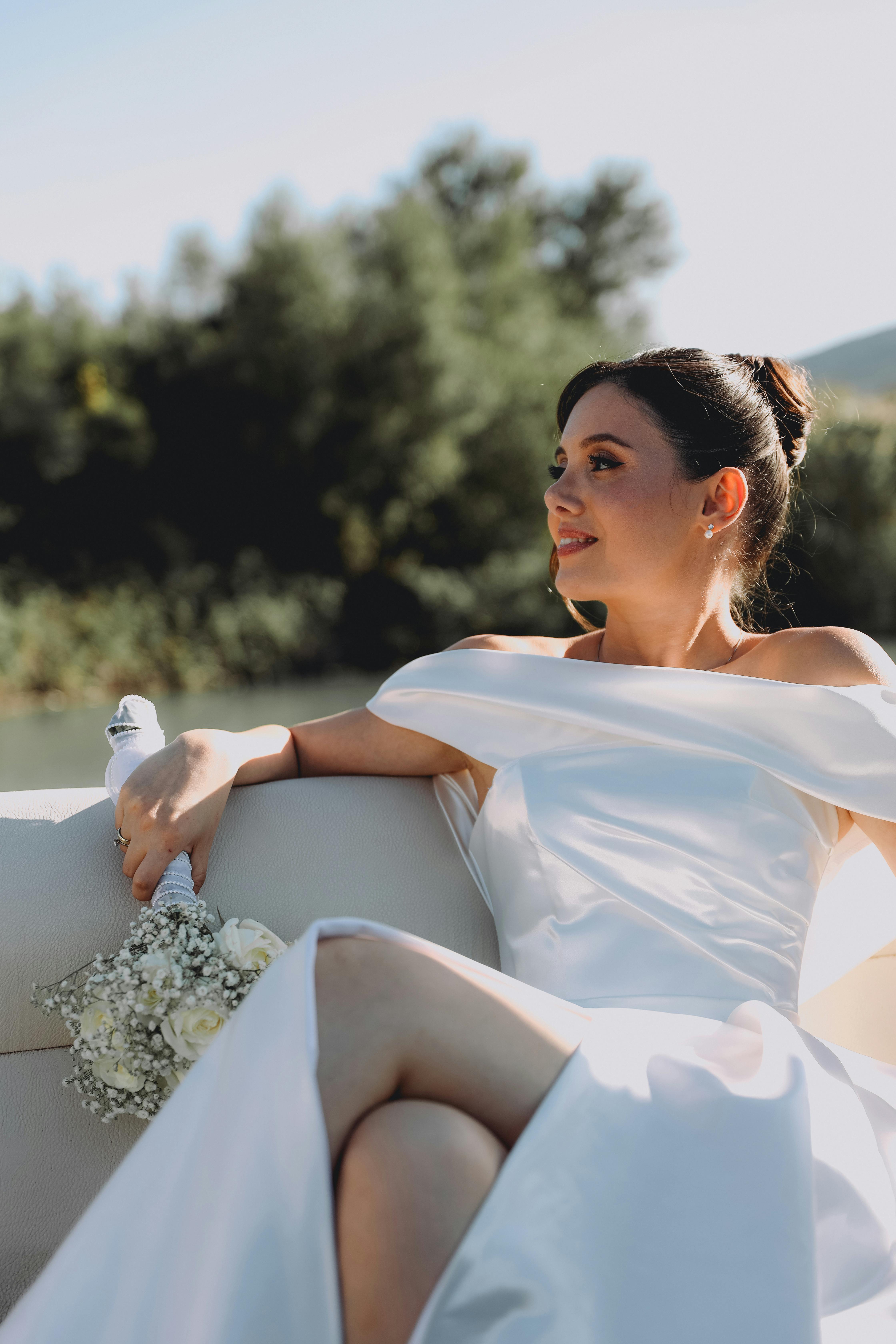 Elegant Bride Relaxing Outdoors on Wedding Day · Free Stock Photo