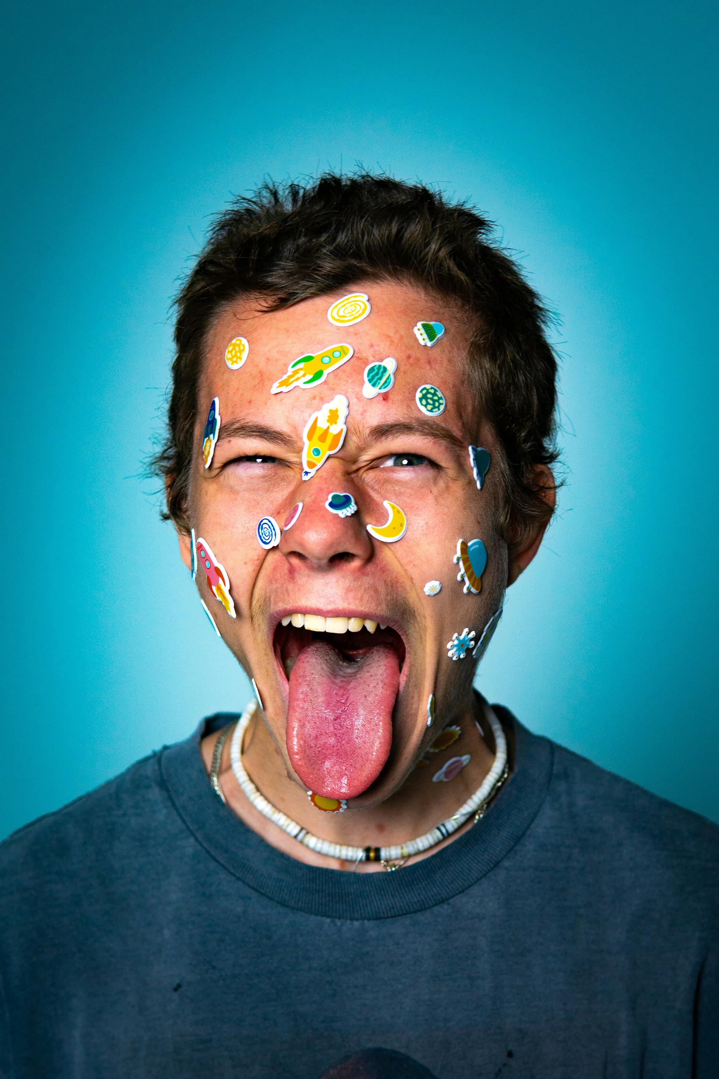 Playful Young Person with Stickers on Face · Free Stock Photo
