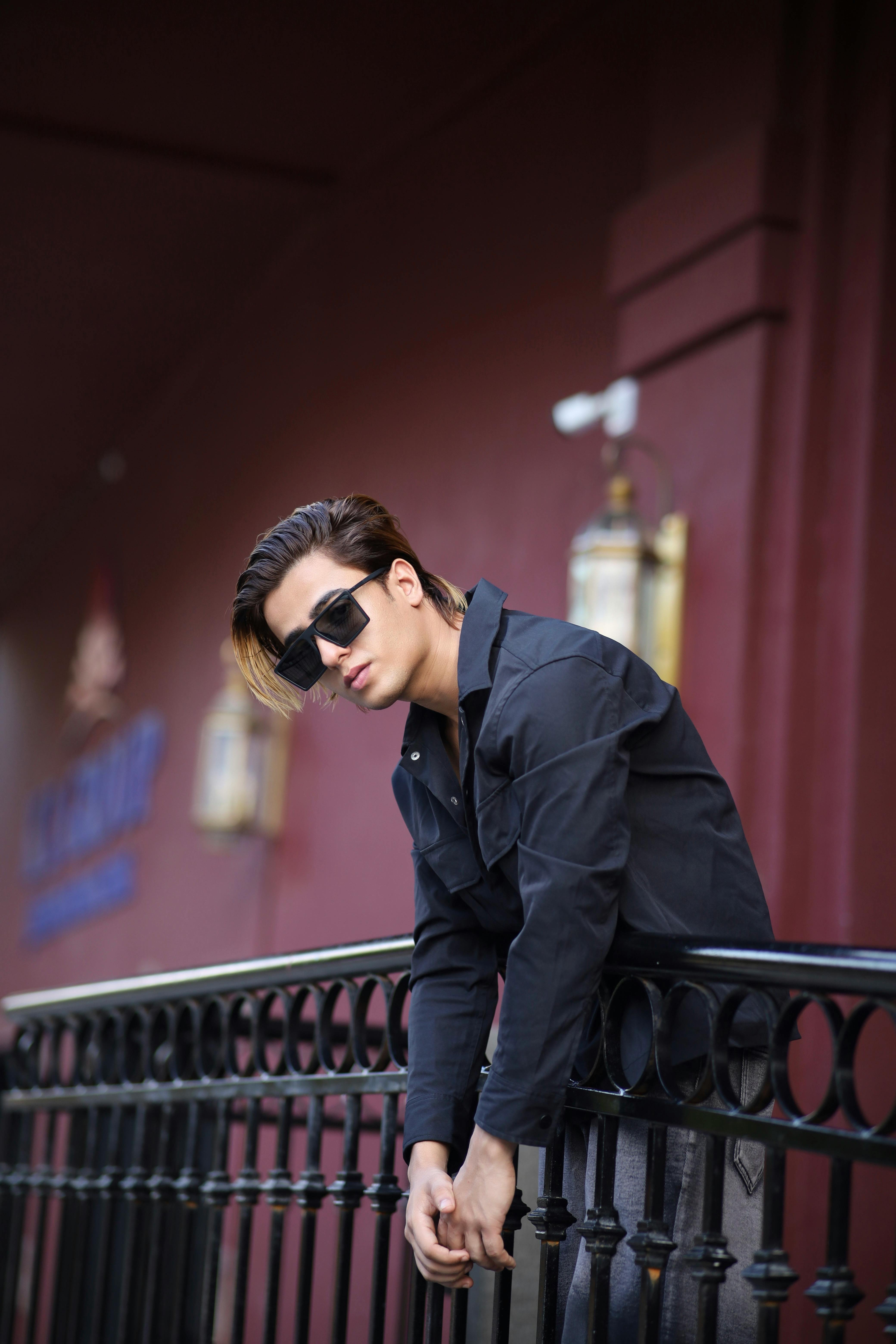 Stylish Young Man Leaning Against Railing · Free Stock Photo