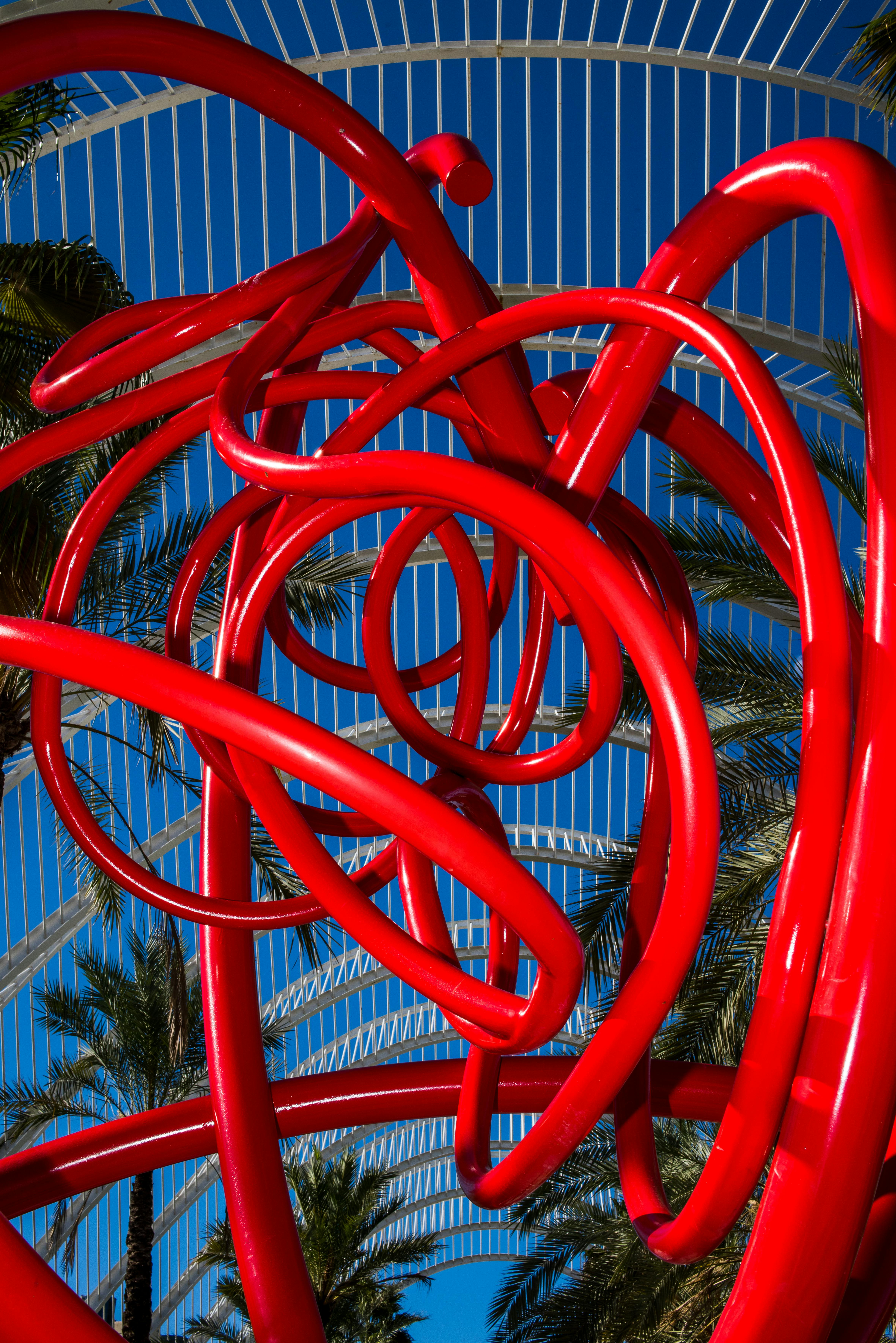 Dynamic Red Sculpture in Urban Park Setting · Free Stock Photo