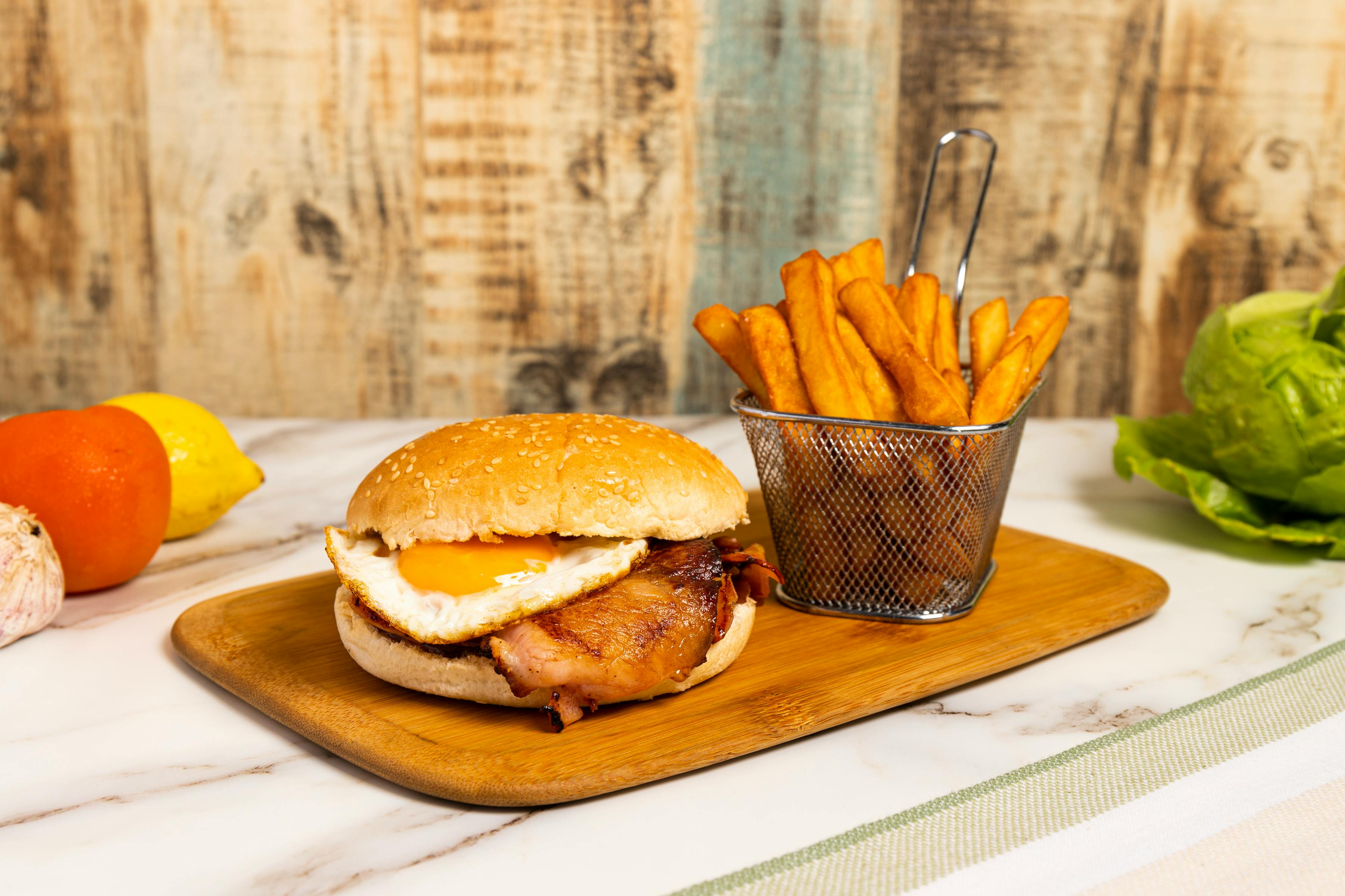Gourmet Burger with Egg and Fries on Wooden Board · Free Stock Photo